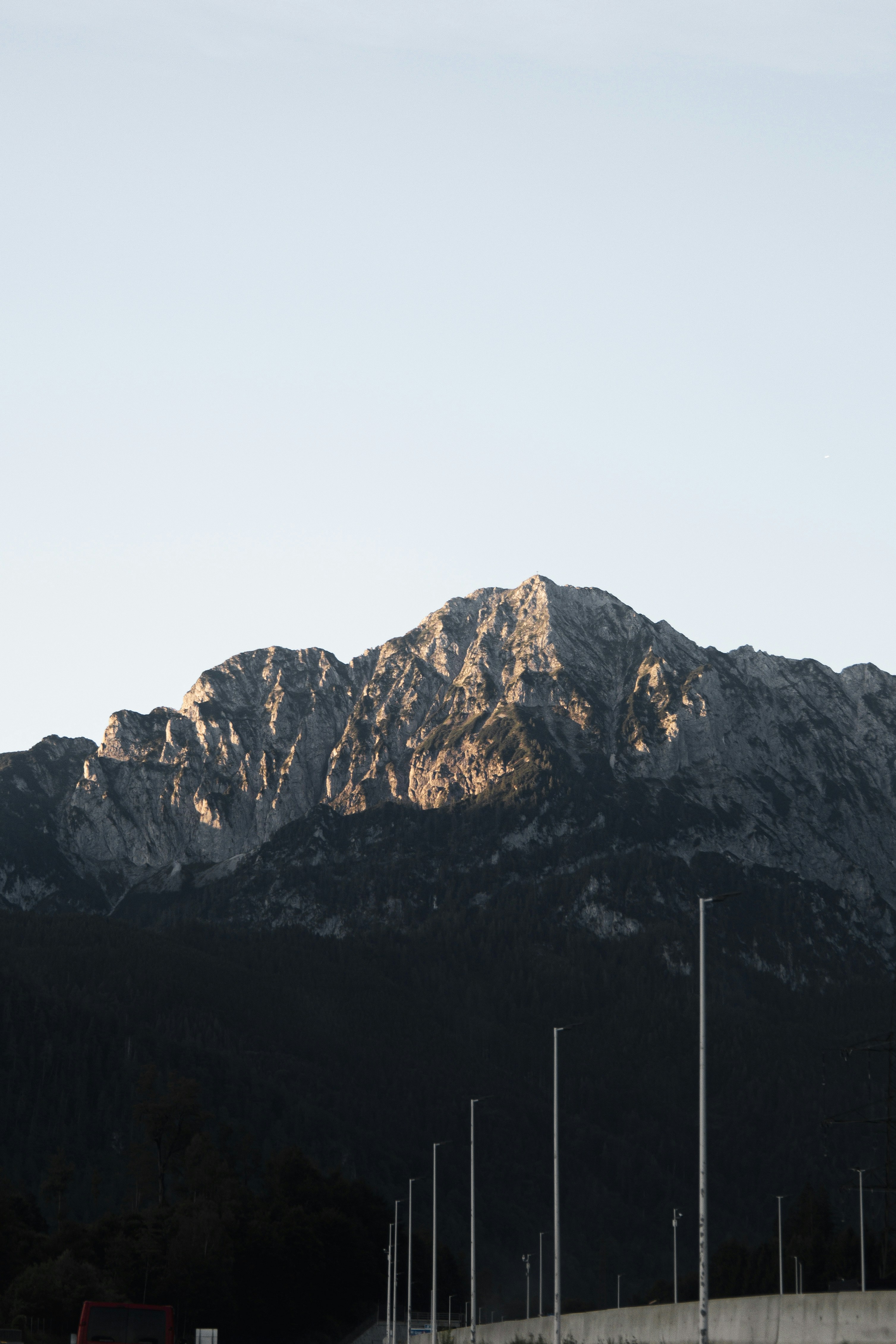 Golden Hour on the Alpine Crest, Framed by Lampposts