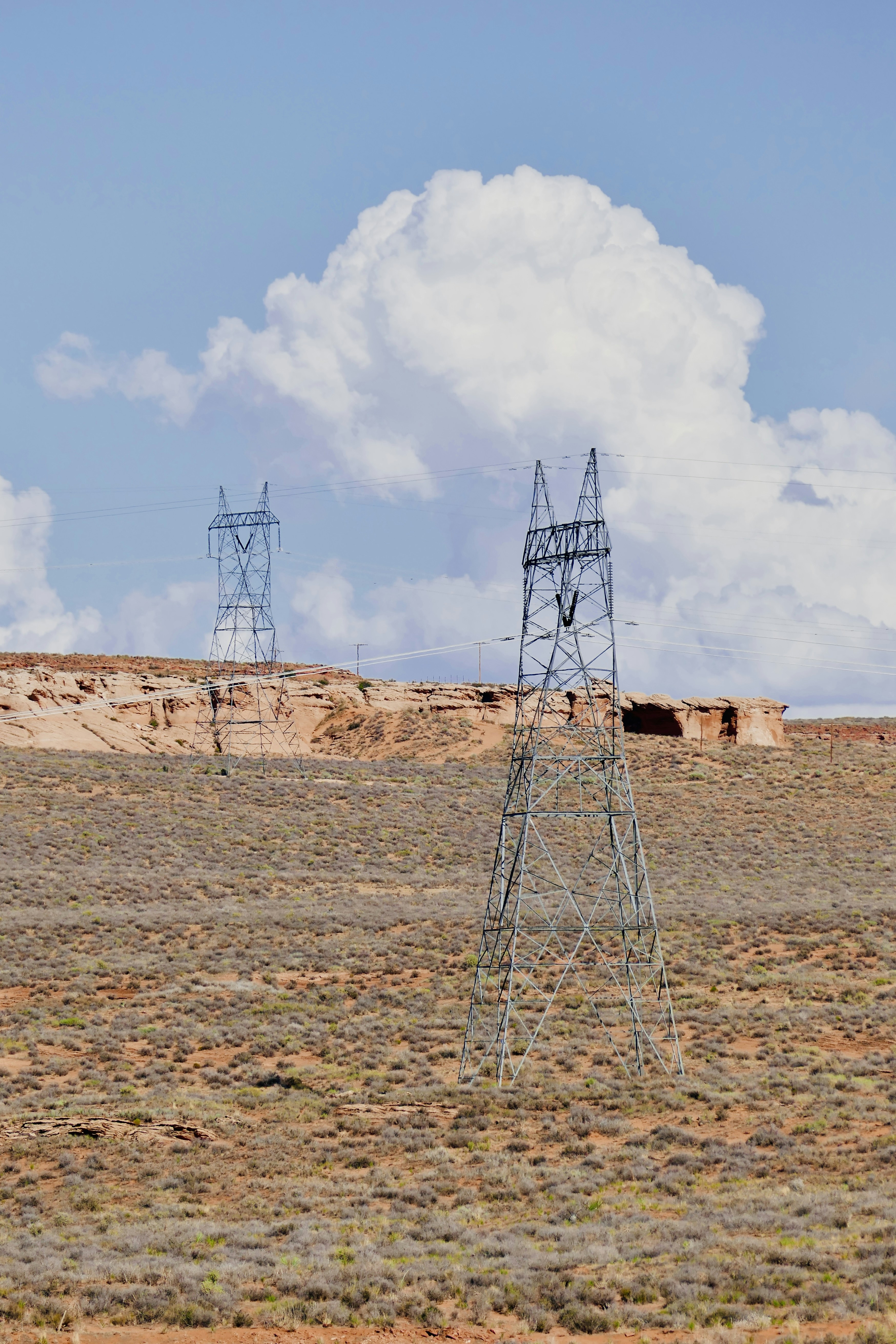 Desert Power Lines: A Lone Lattice Crowned by Clouds