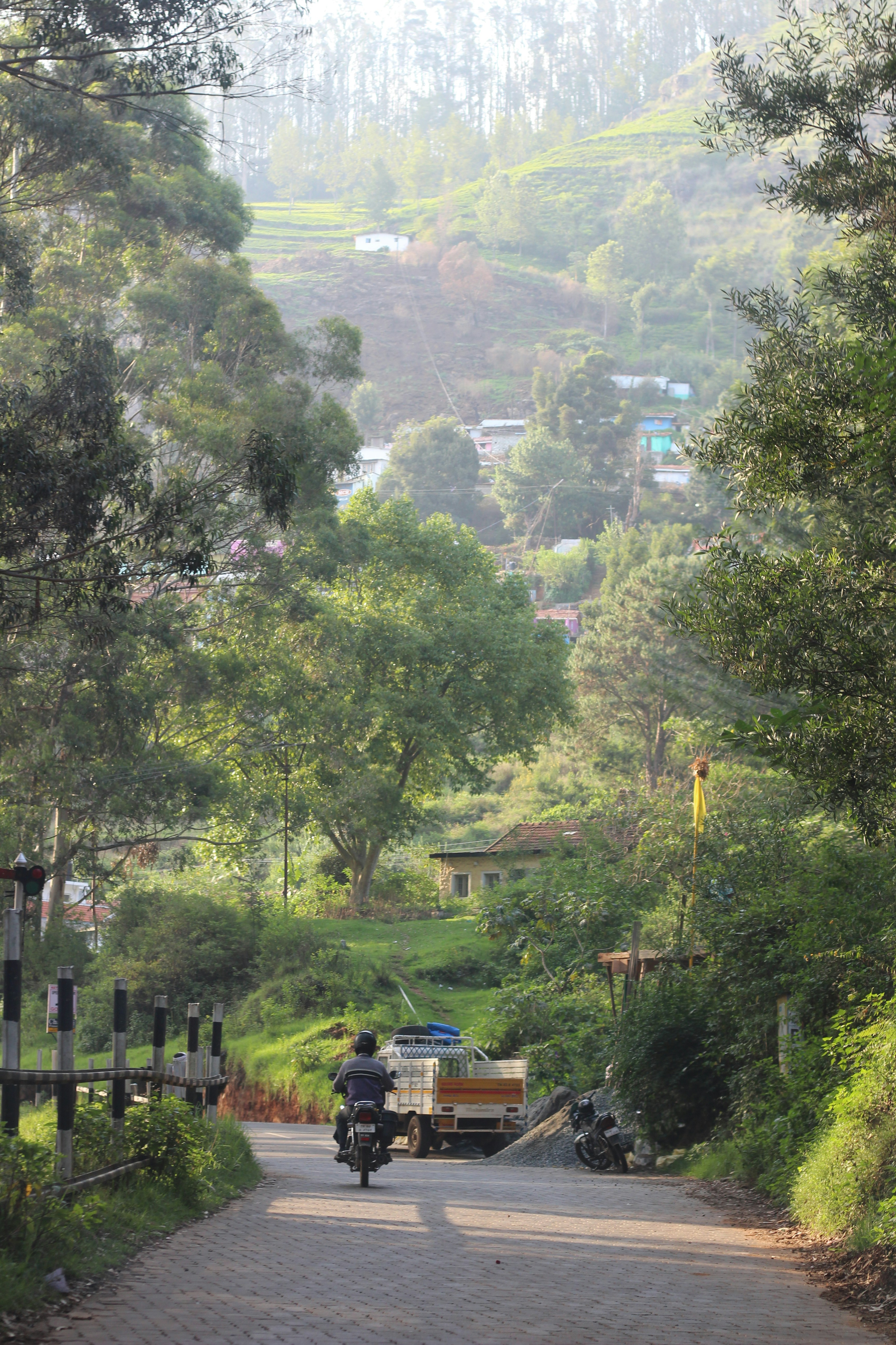 Lone Rider Down a Quiet Hill Road Framed by Verdant Terraced Slopes
