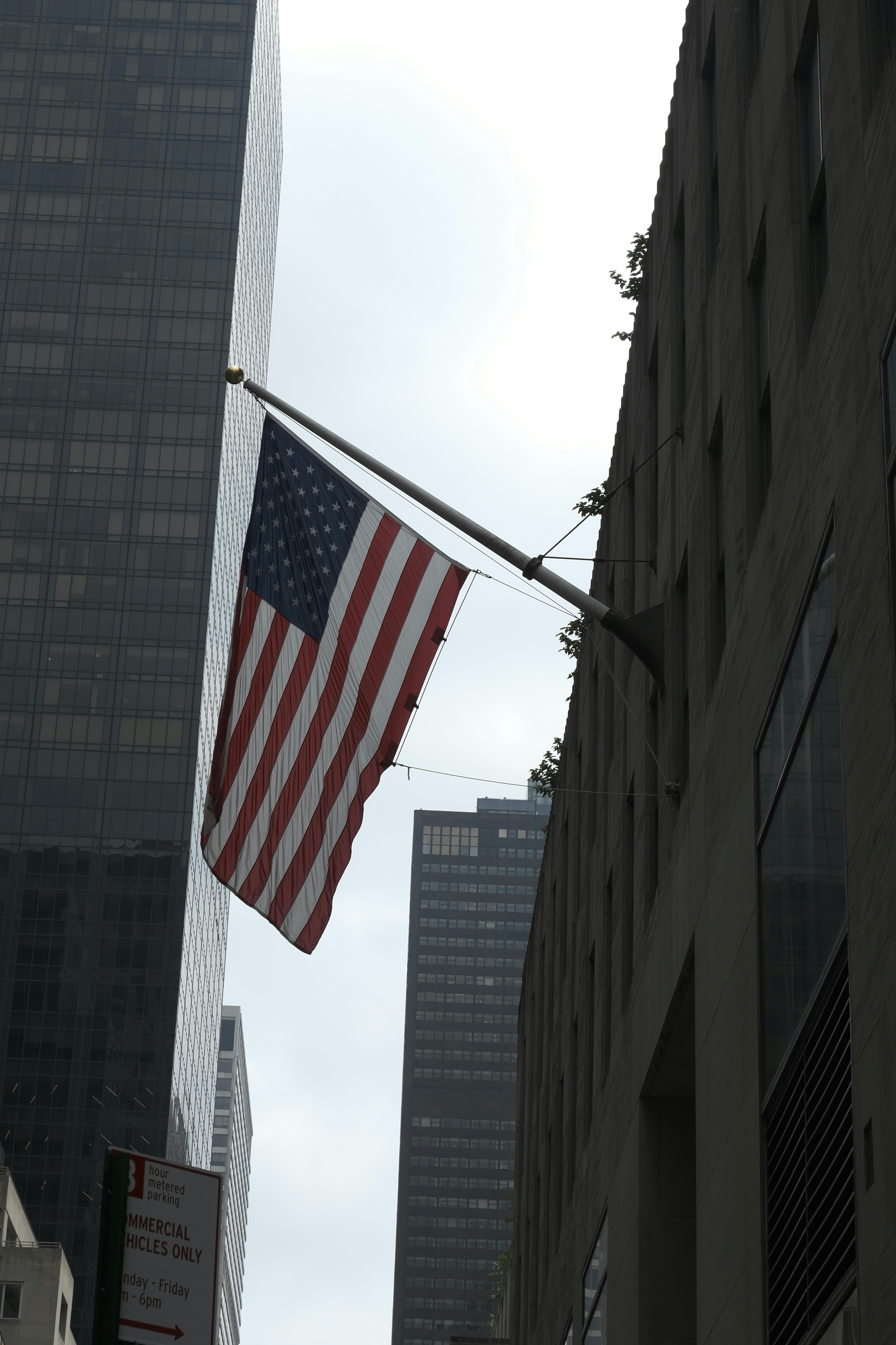 Flag Between Glass Giants: a City Portrait in Muted Daylight