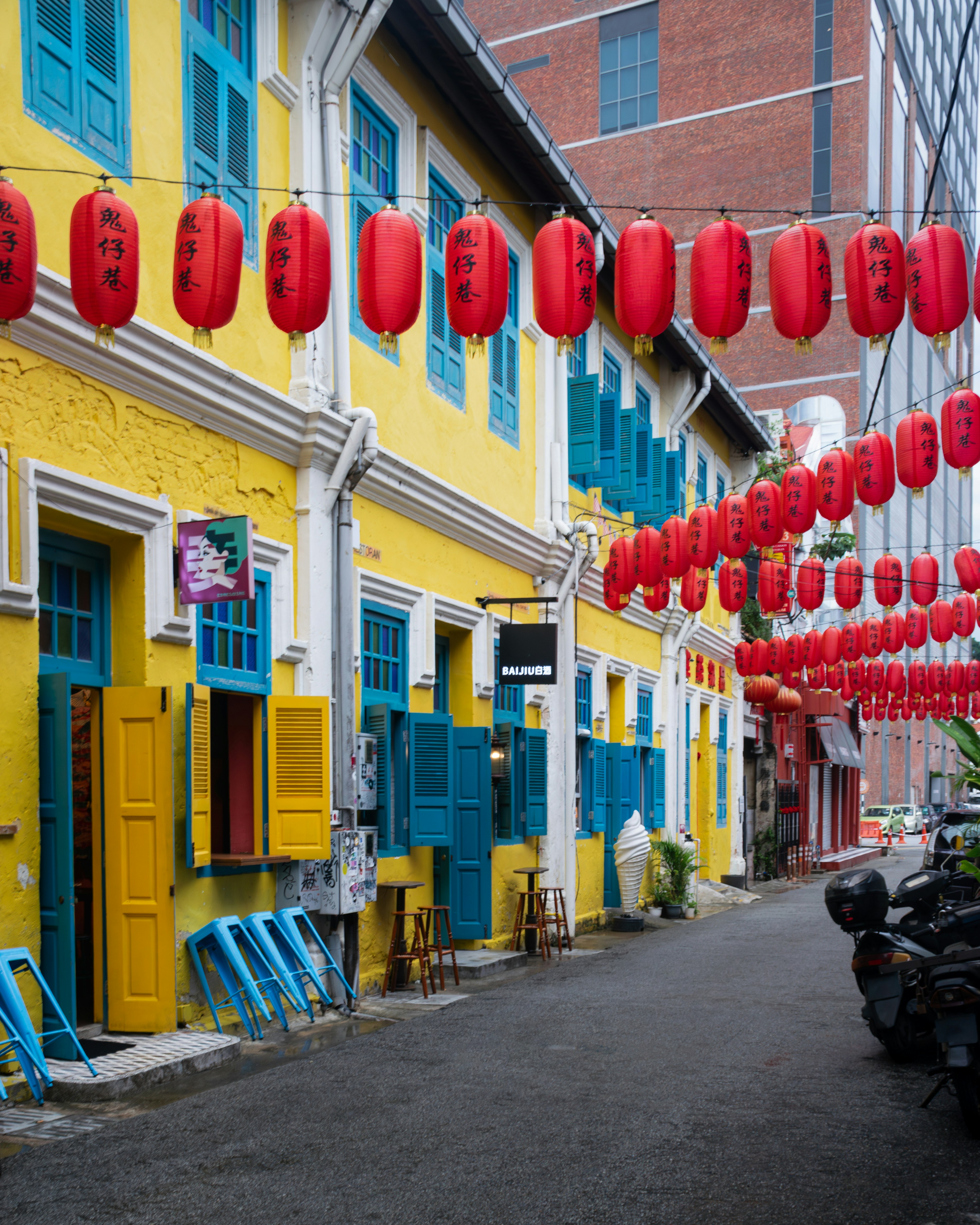 Sunlit Calle of Red Lanterns and Blue Shutters
