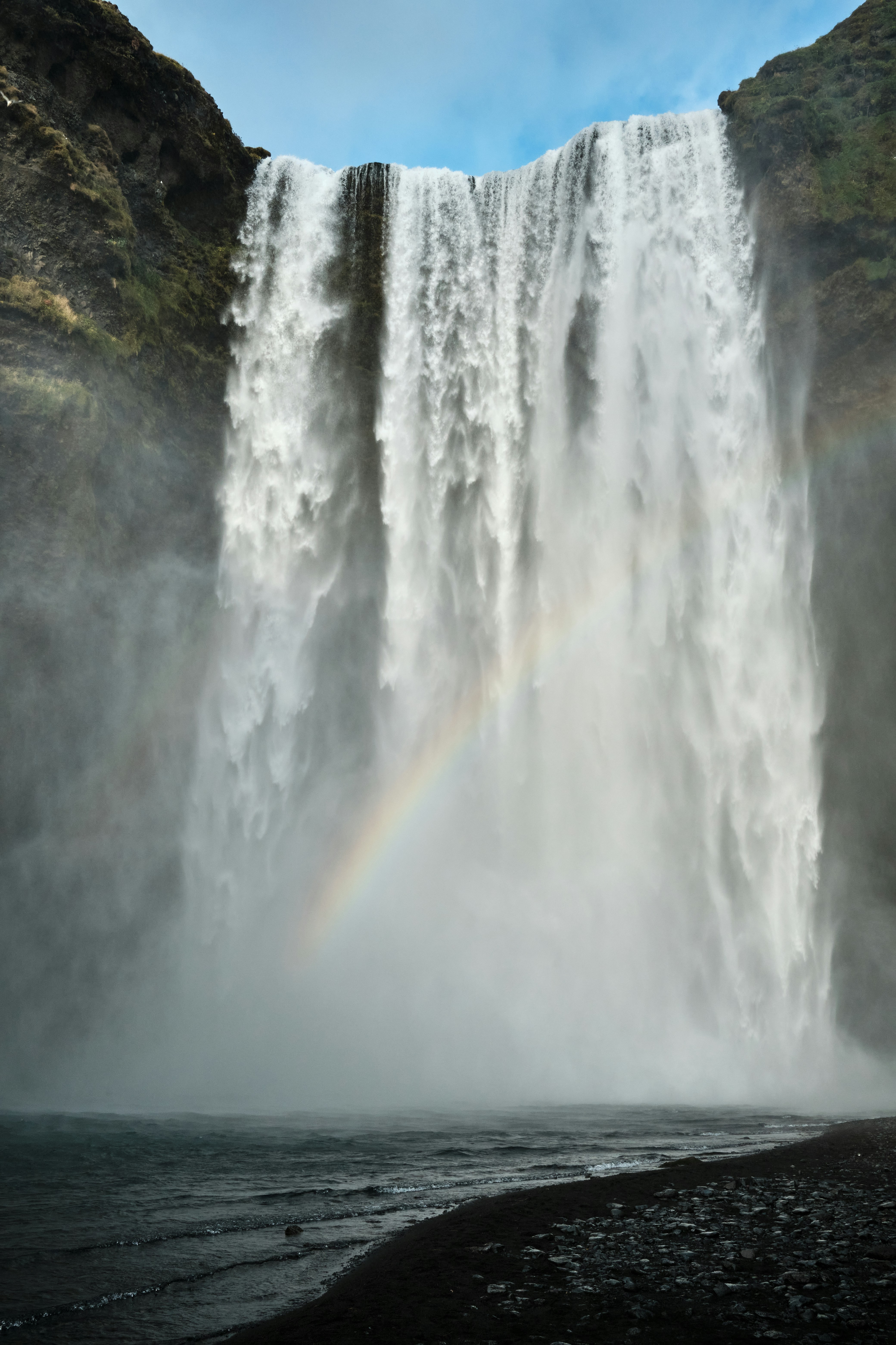 Rainbow Arches Through Mist Over a Thunderous Cascade
