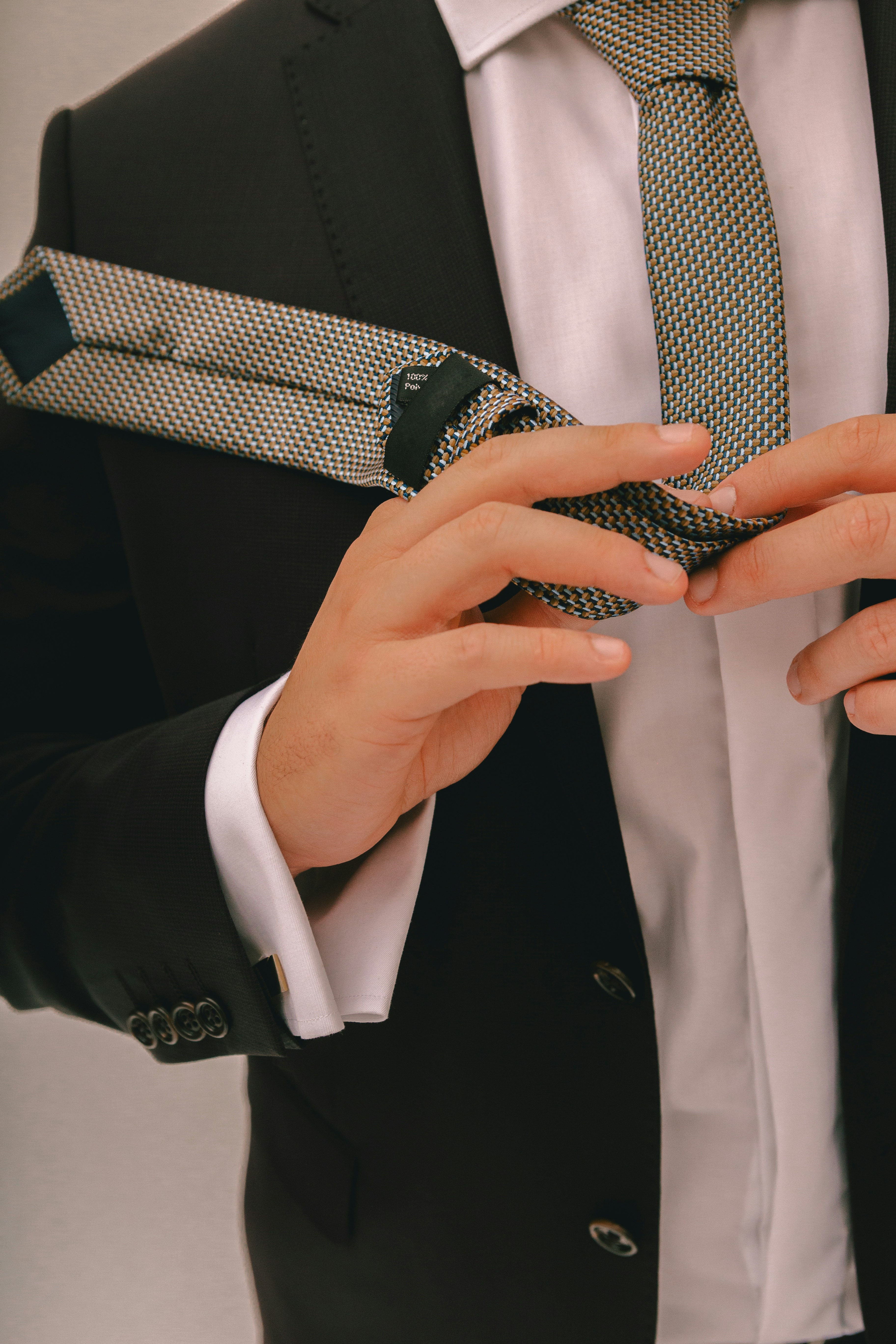 A man in a suit tying a tie photo – Free Tie Image on Unsplash