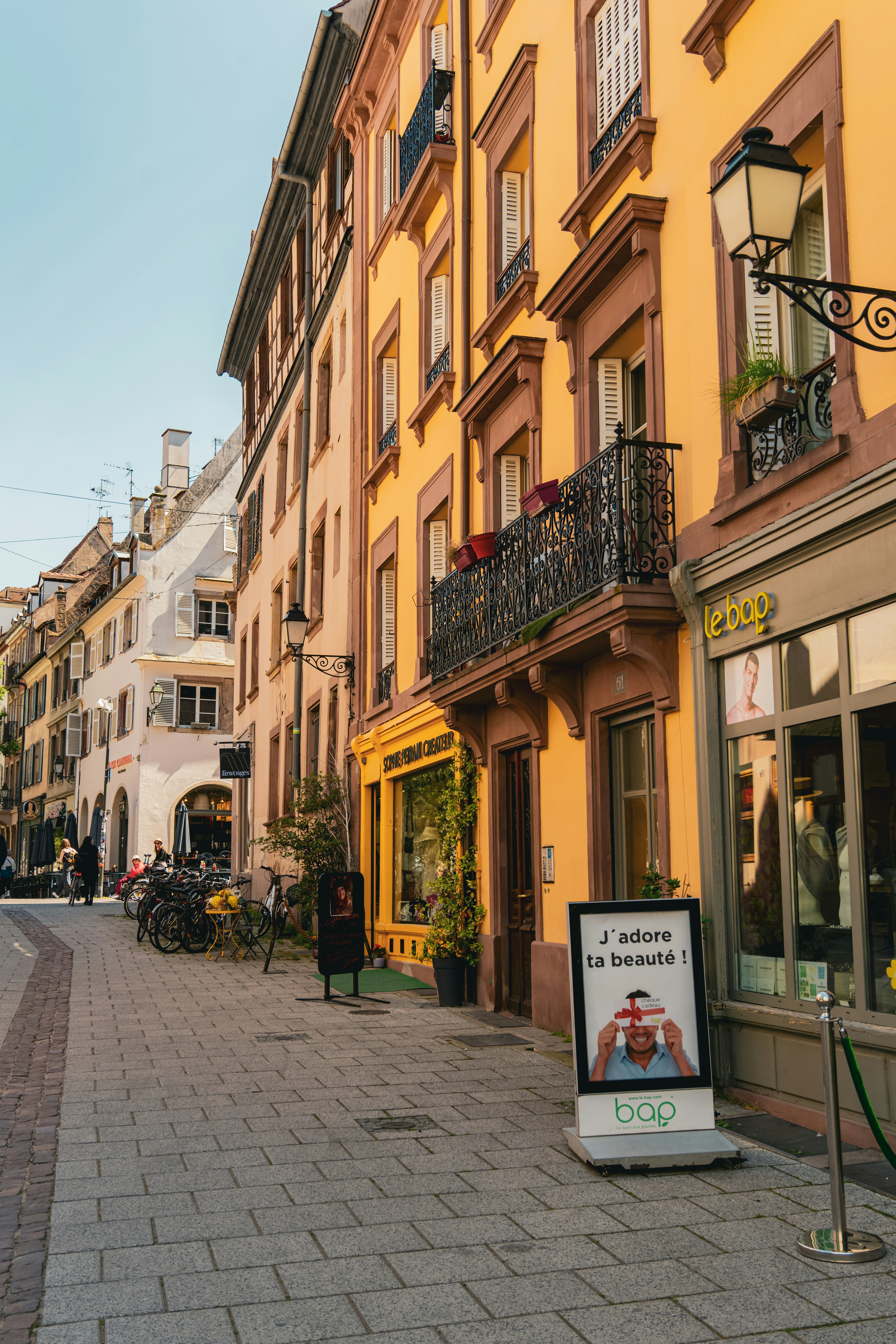 A city street lined with tall brown buildings photo – Free Urban Image ...