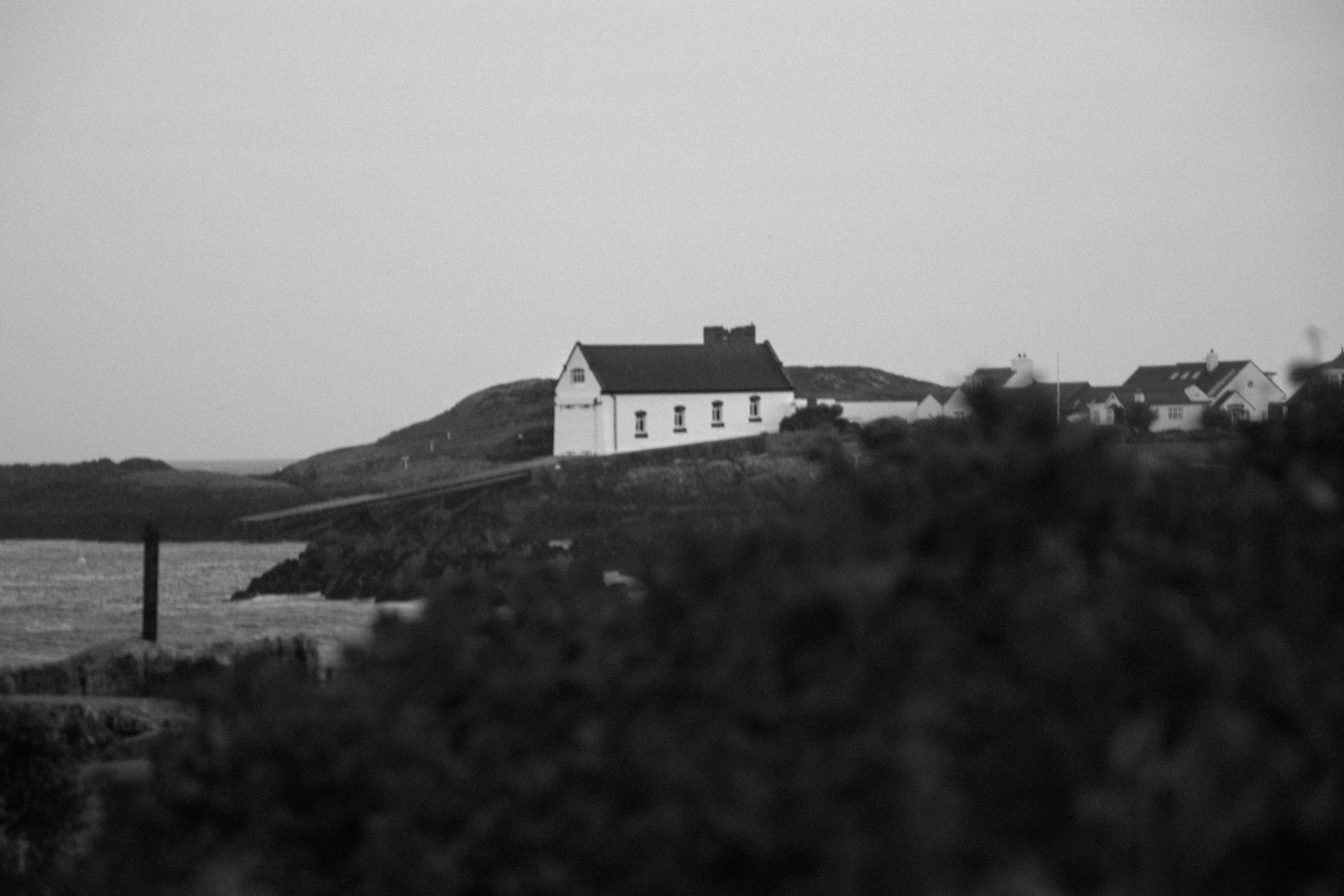 Promontory White: A lone coastal house in monochrome