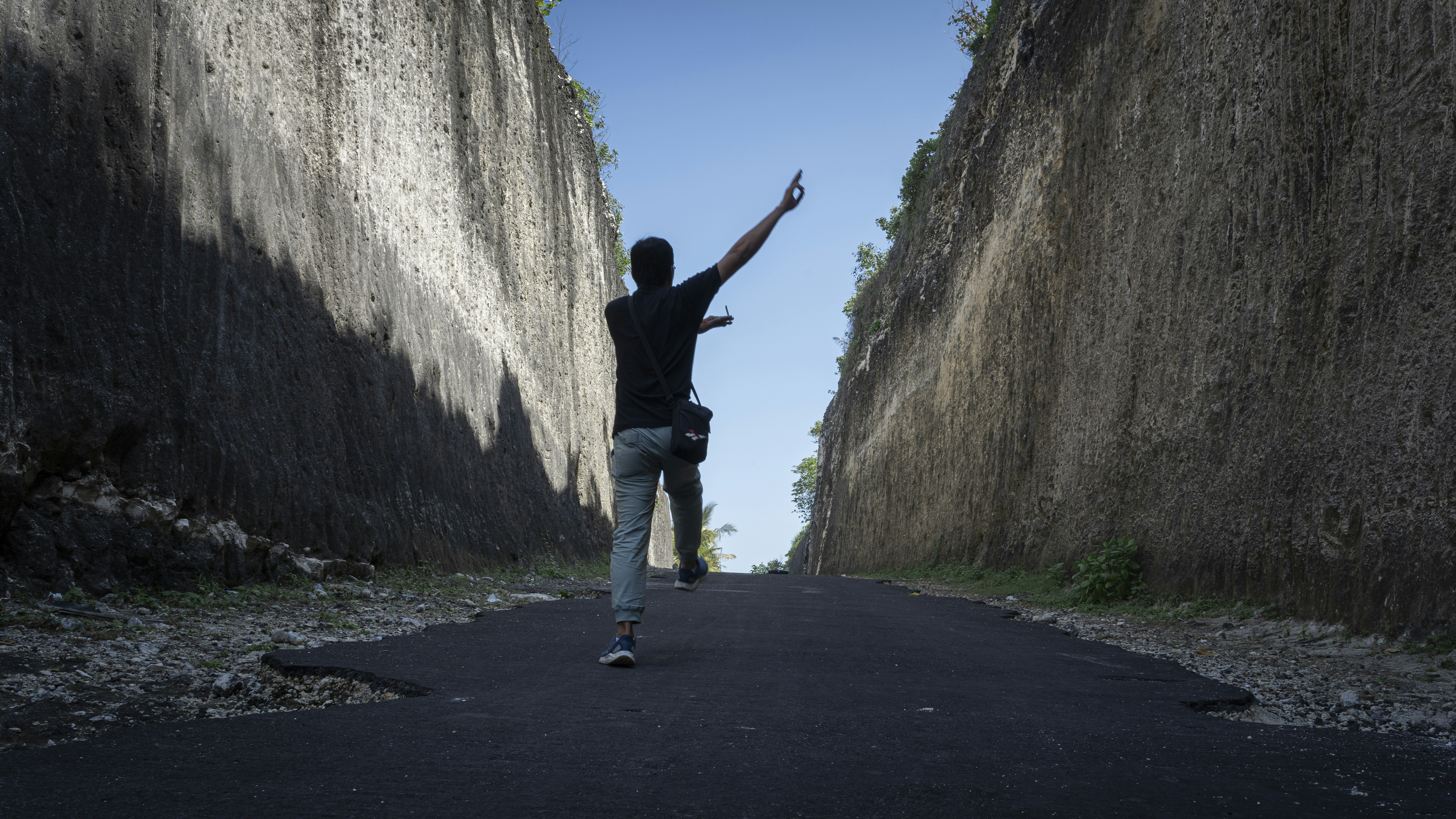 Silhouette in the Canyon Corridor: A Figure Reaches Toward the Sky