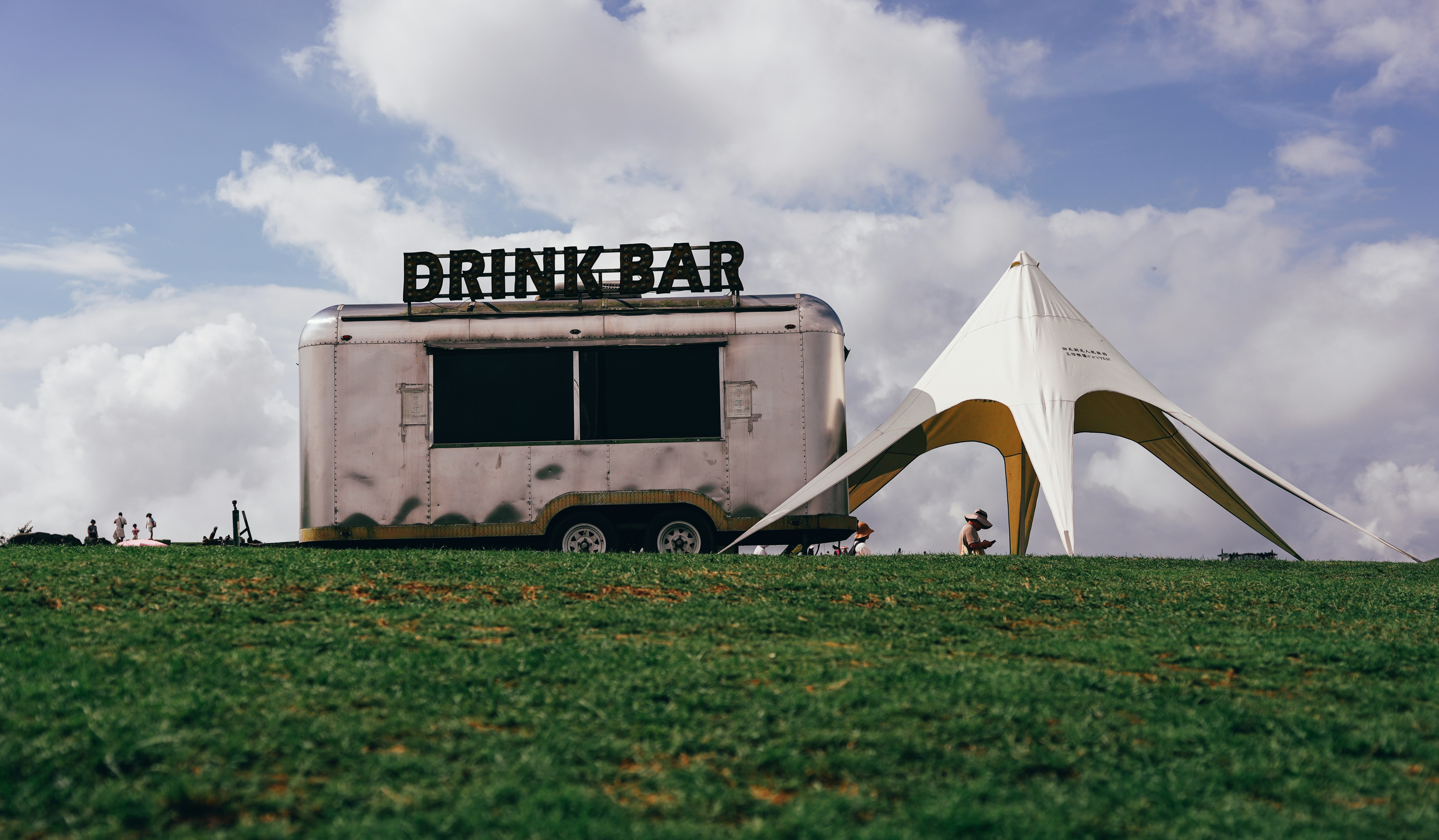 A food truck parked on top of a lush green field