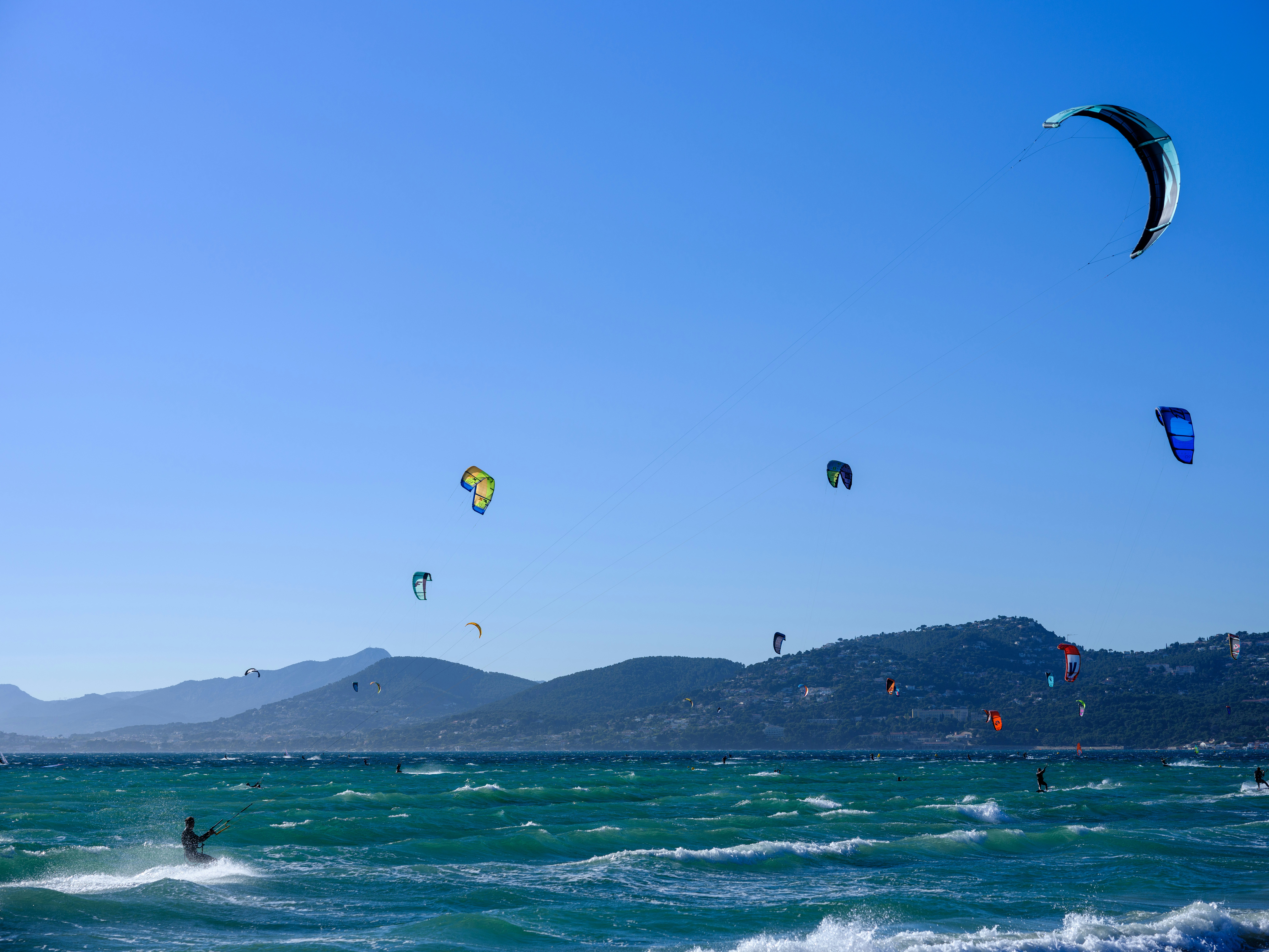 A group of people flying kites over the ocean photo – Free Beach Image ...