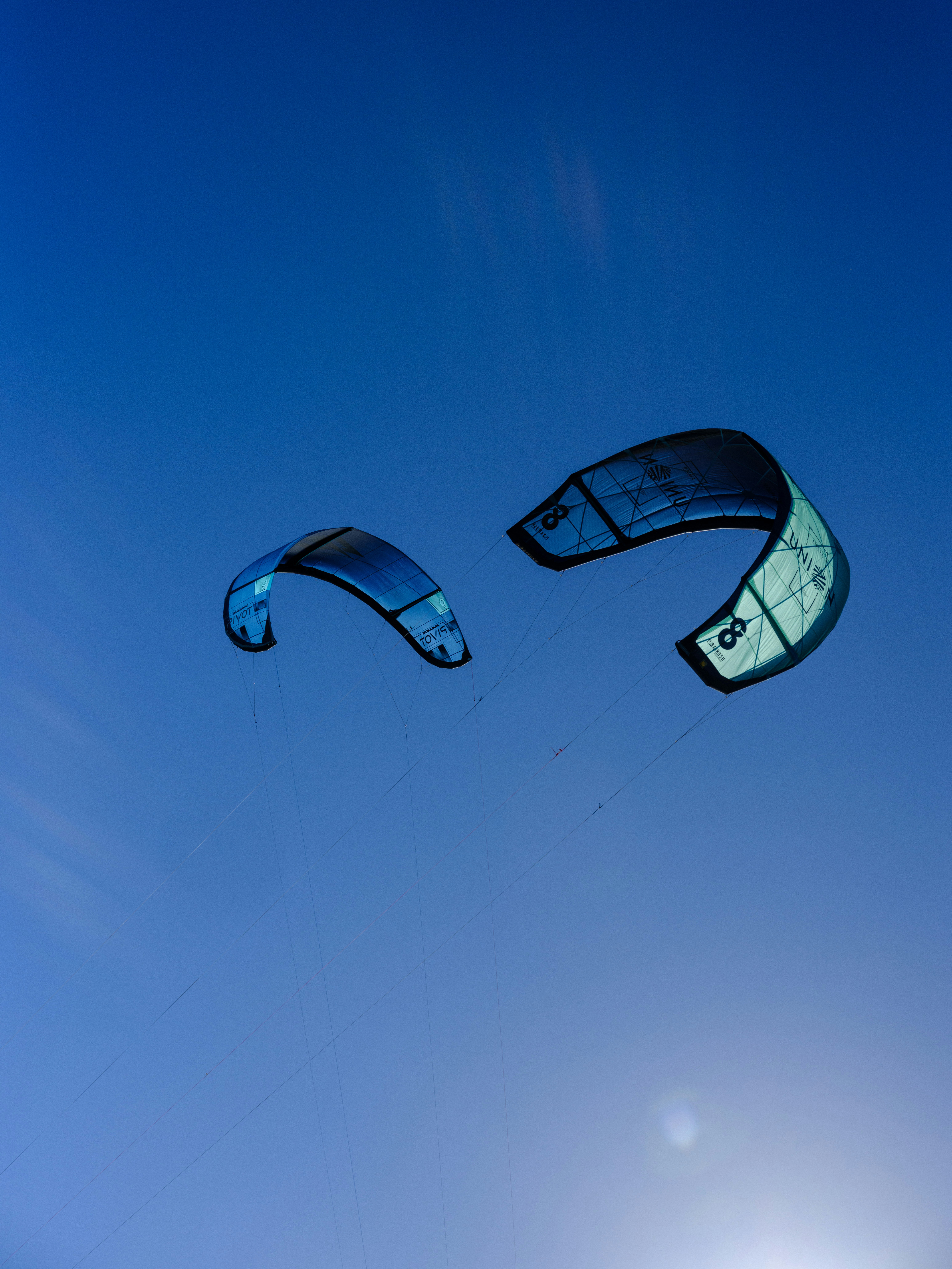 Canopy Duet: Two Paragliders Sketch a Curve Across a Cerulean Sky