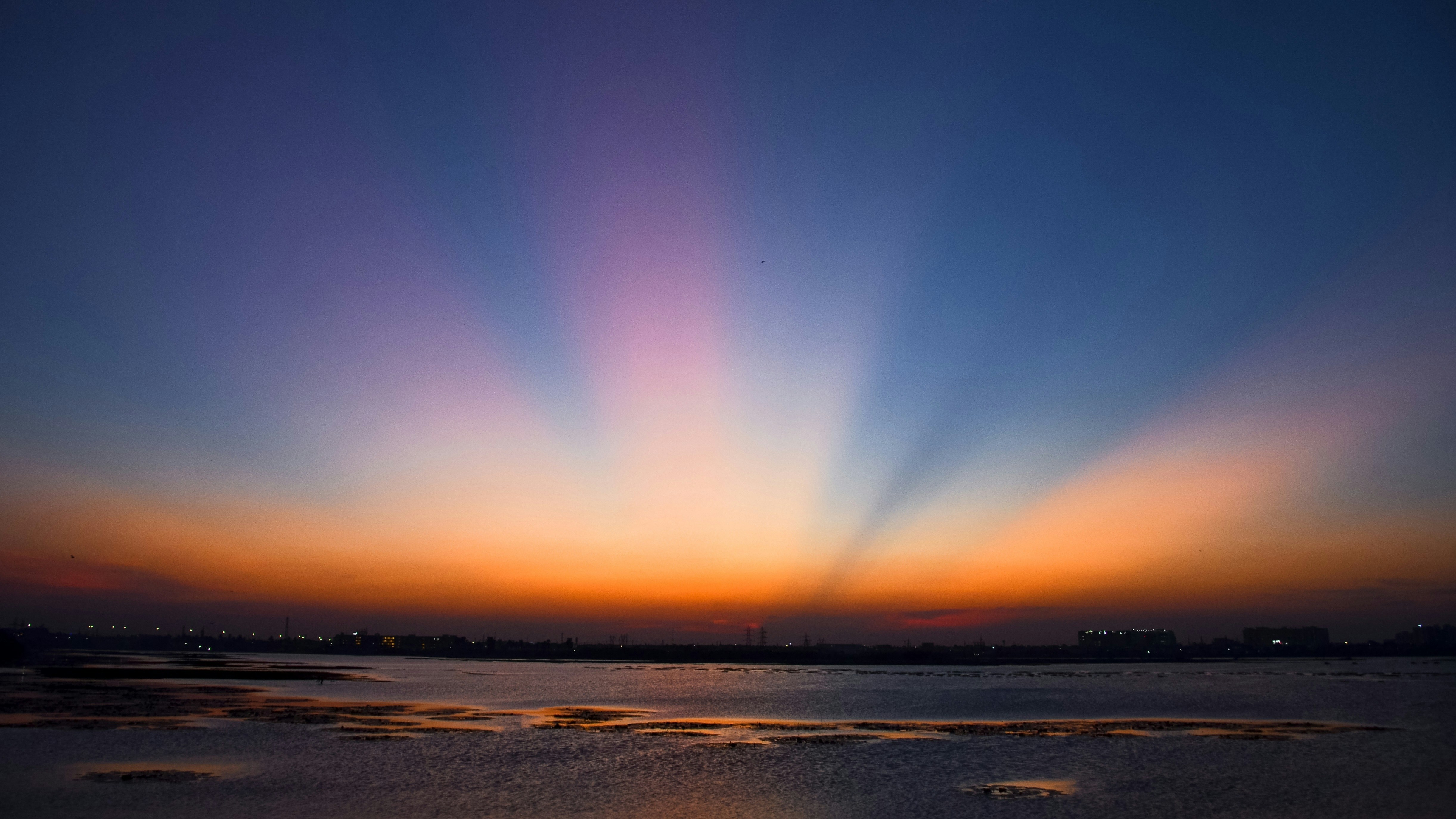 Converging Sunset Rays Over a Quiet Shore