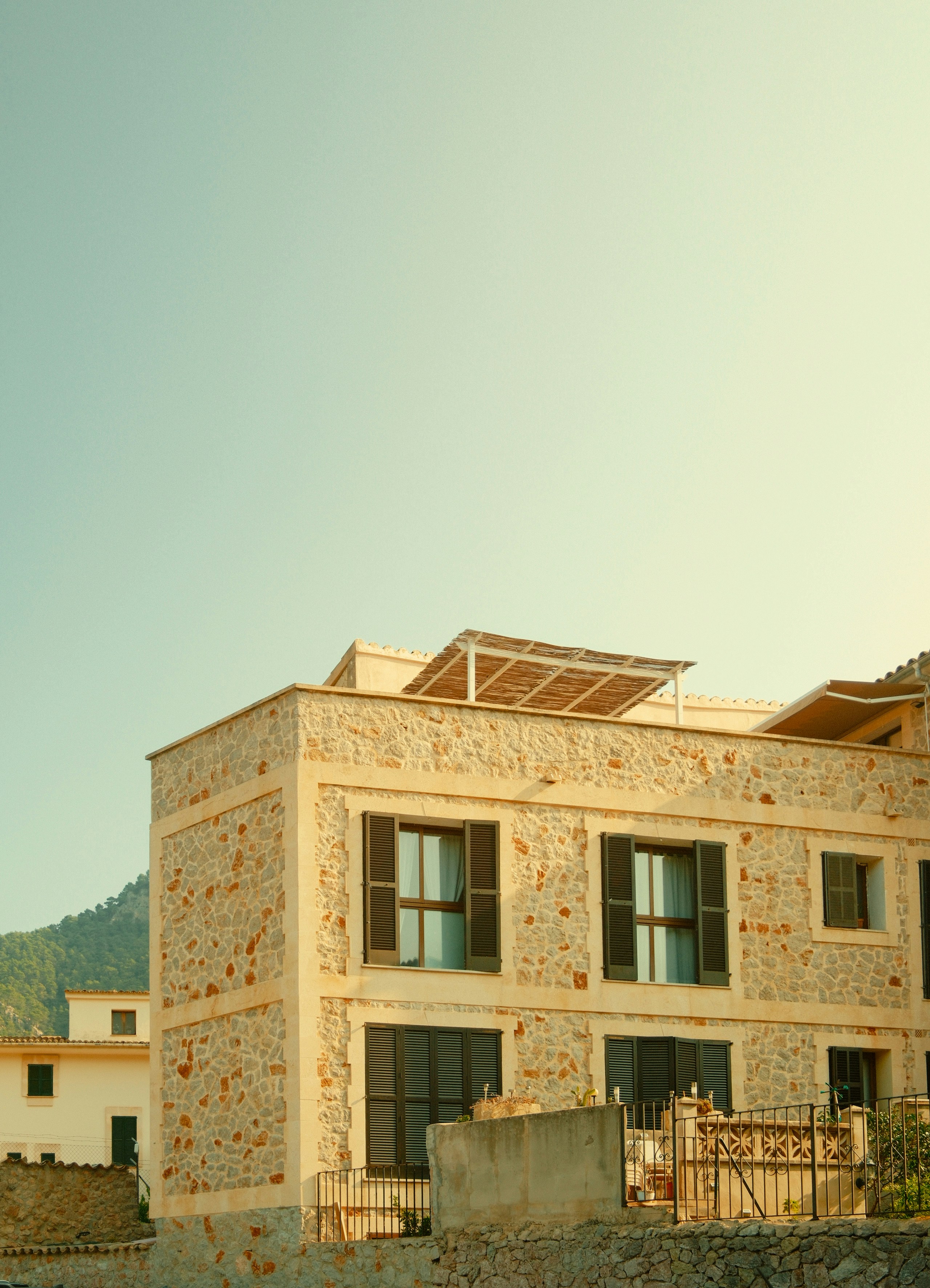 Sunlit Stone Villa Framed by a Pale Sky