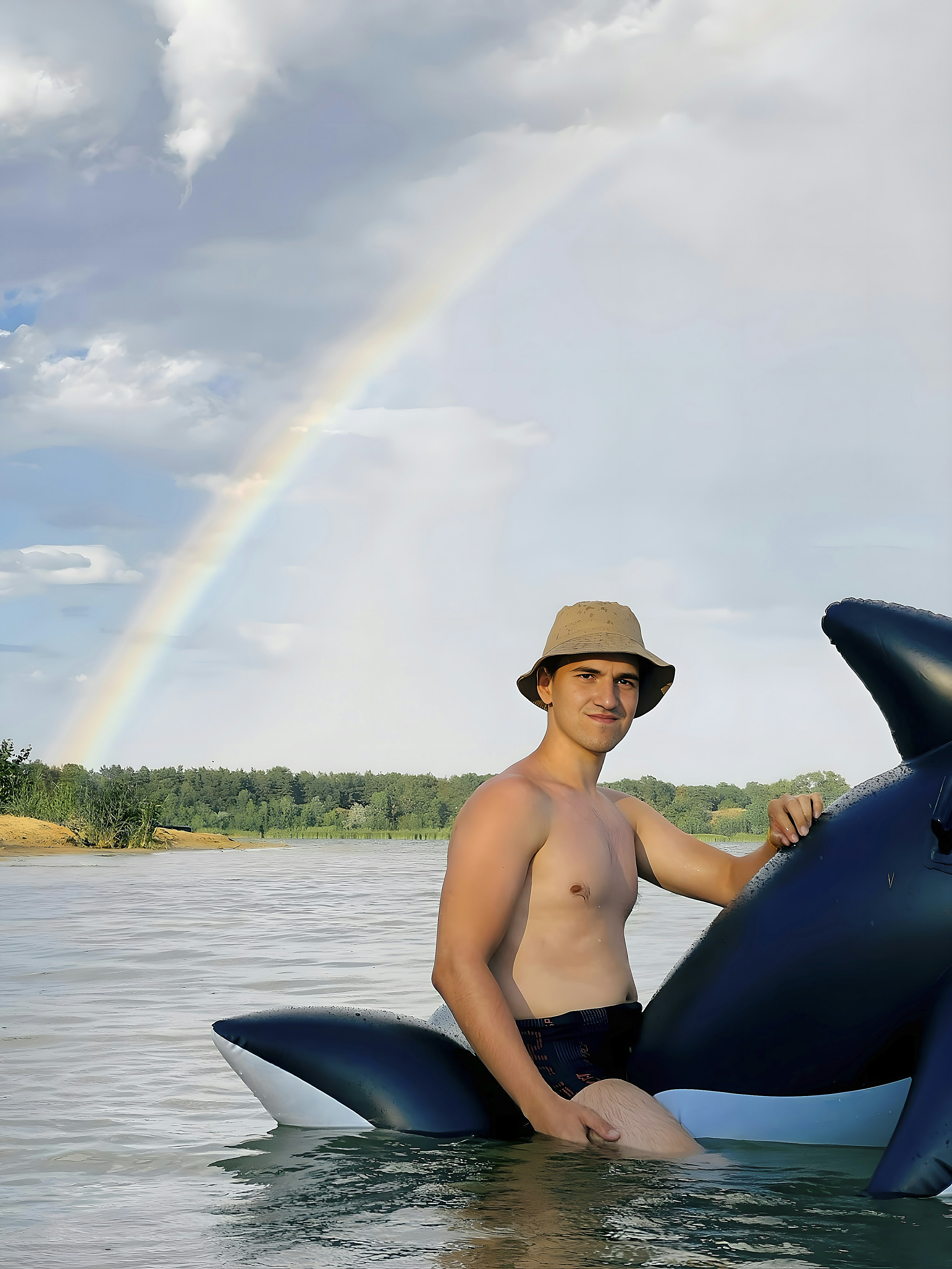 A man standing in the water next to a fake dolphin photo – Free Beach ...