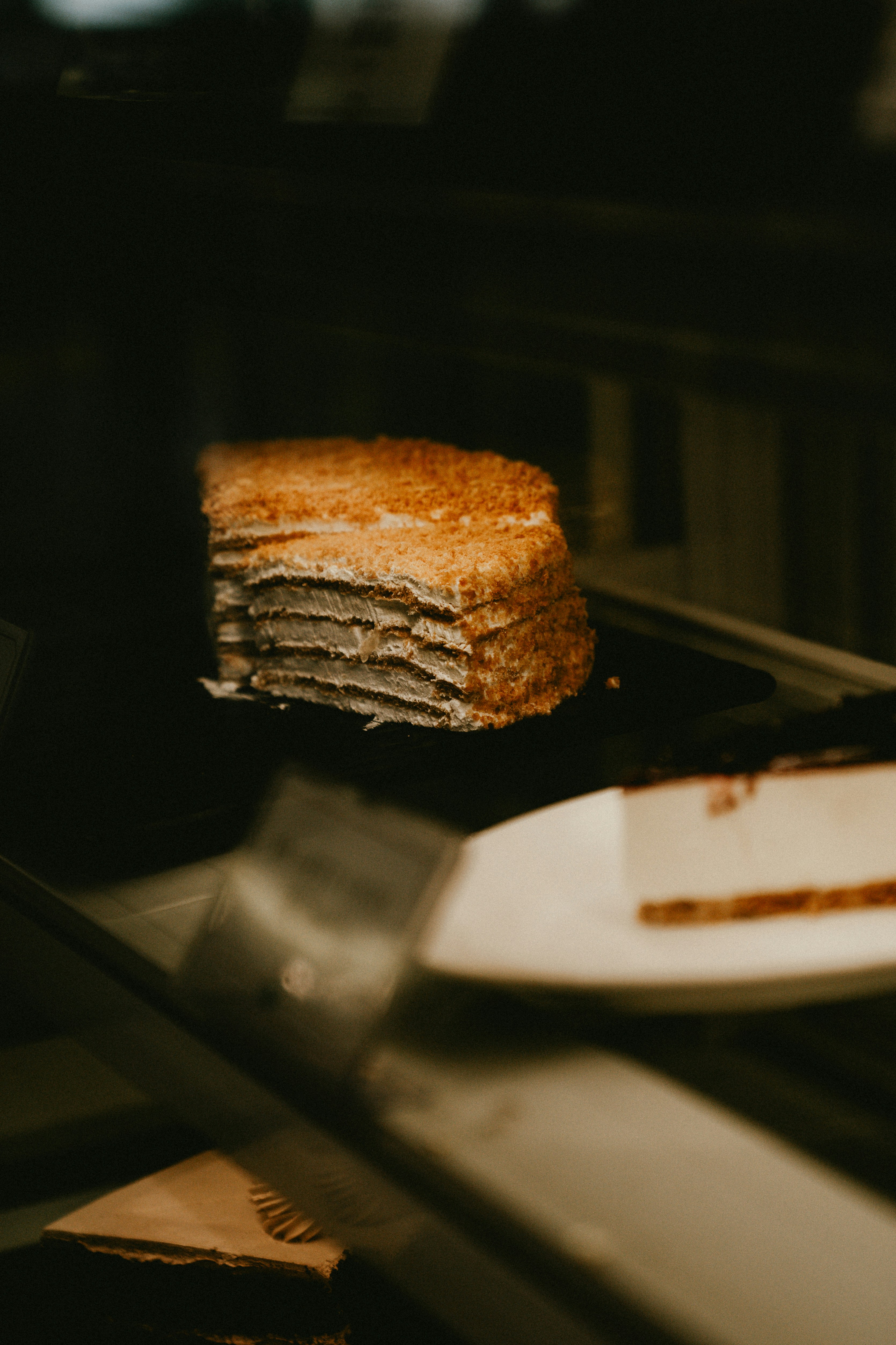 Caramel-Crusted Layered Loaf Glimpsed Through a Dim Bakery Display