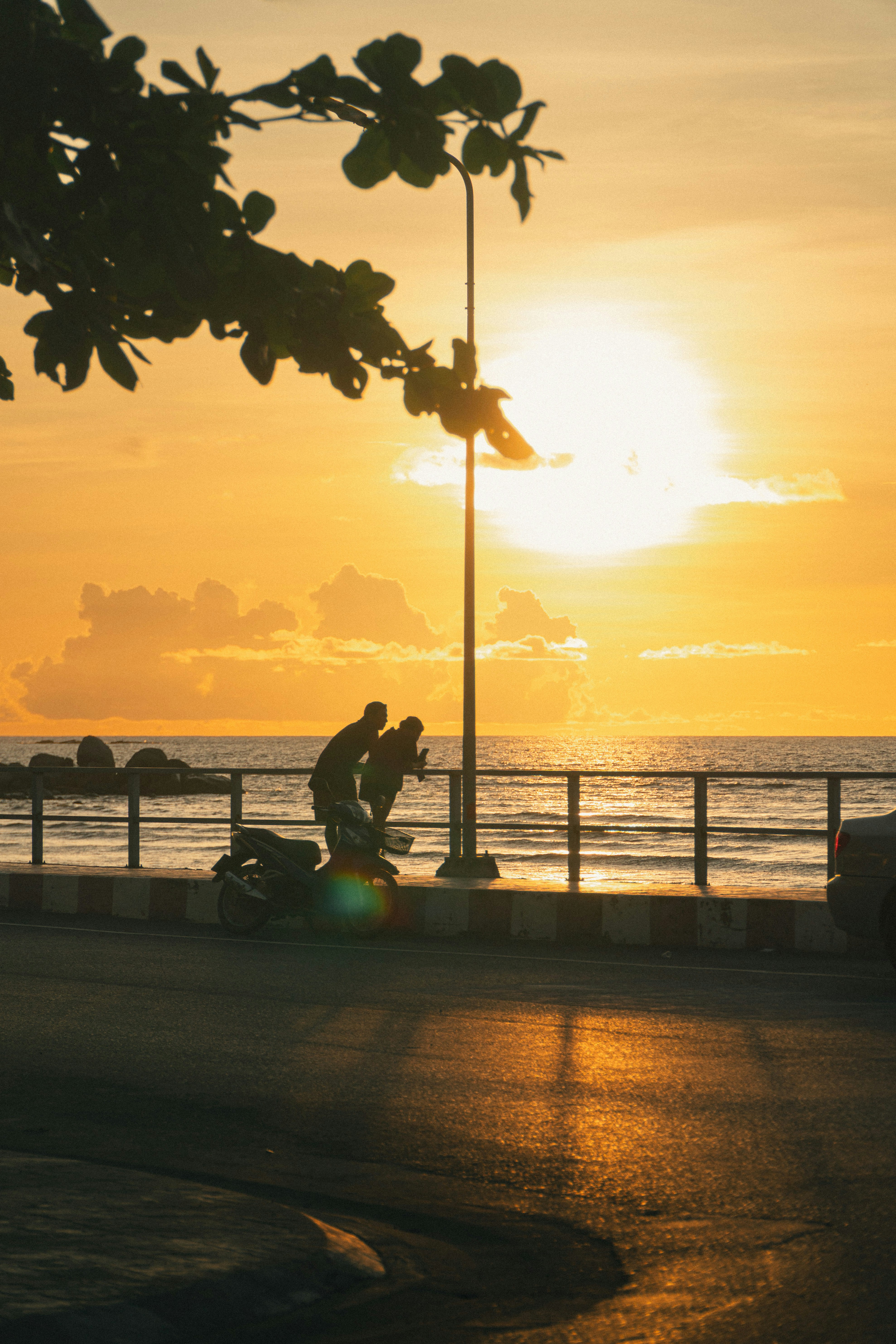 Seaside Sunset Rendezvous: Lovers Lean Over the Rail at Golden Hour