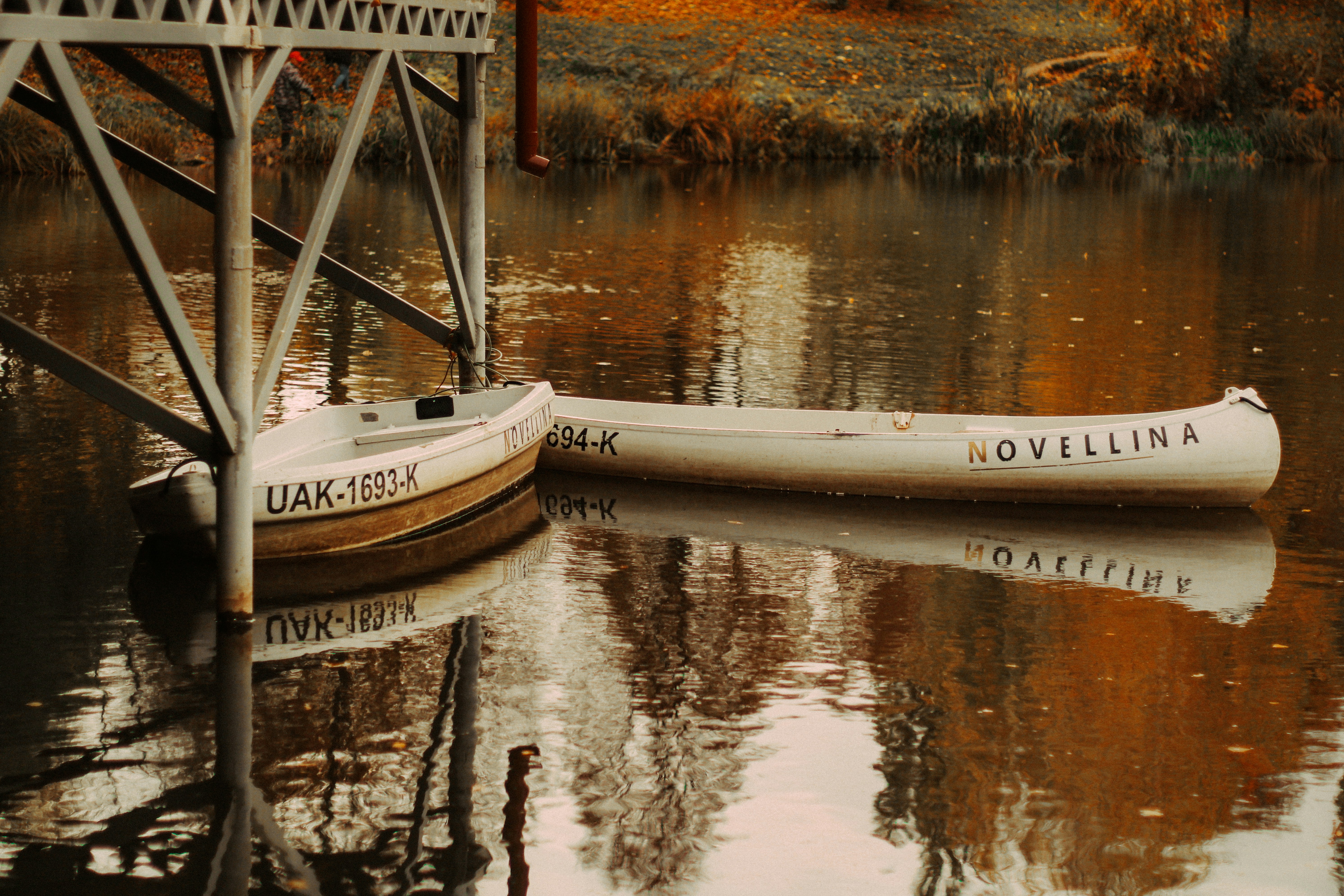 Amber Reflections at a Quiet Dock: Two Boats Rest Along the River