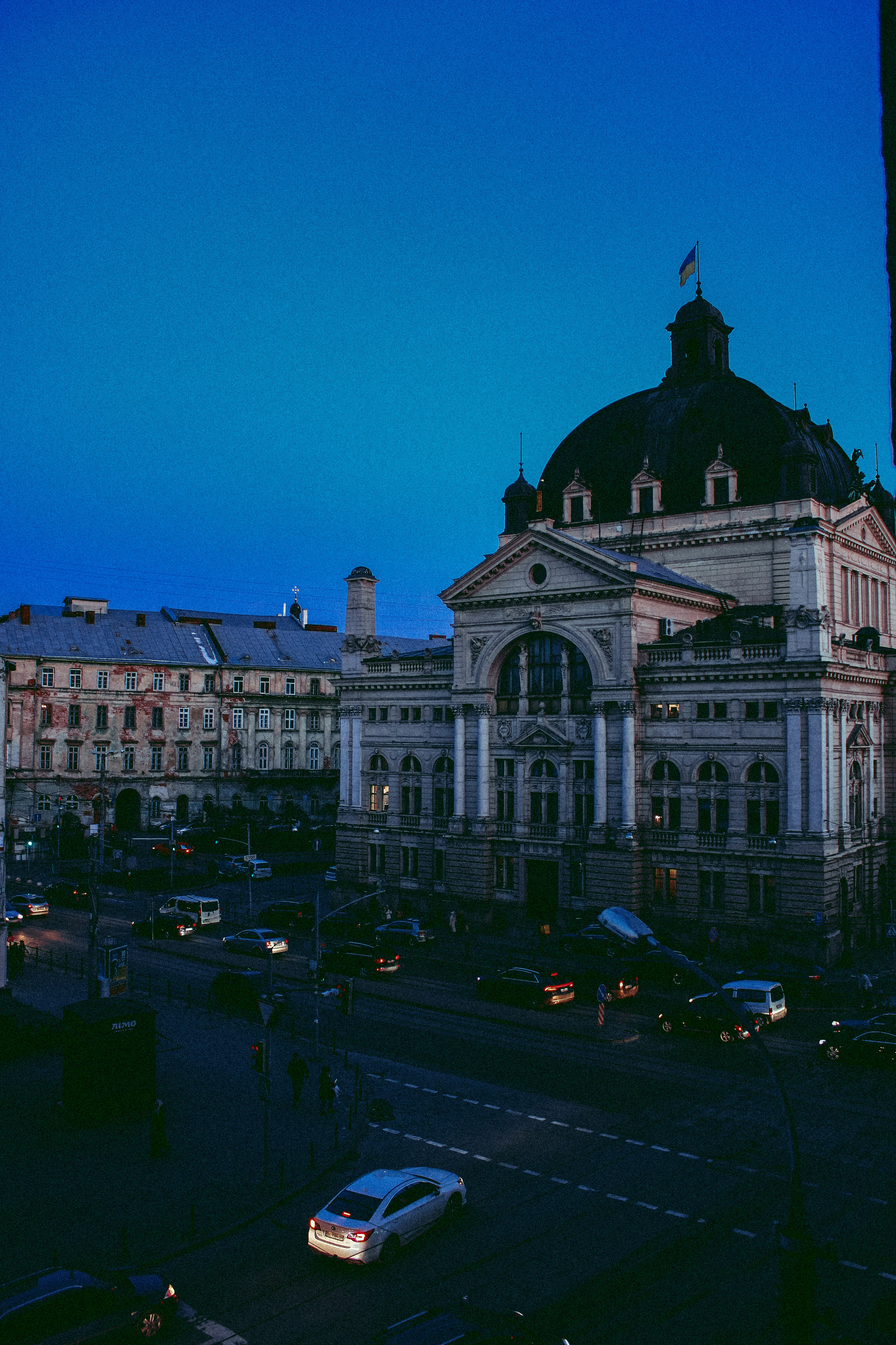 Blue Hour Dome: Neoclassical Opera House Amid a Lively City Street