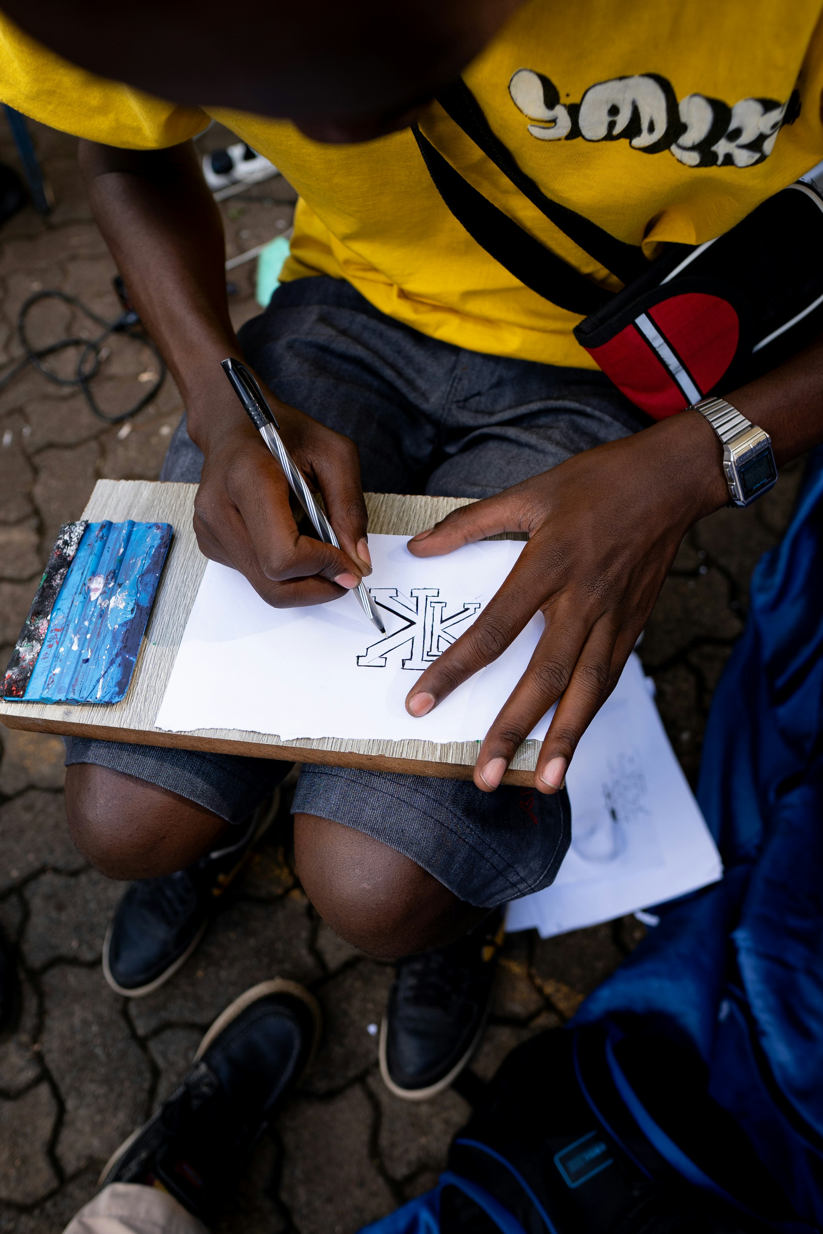 A person sitting down writing on a piece of paper photo – Free Art ...