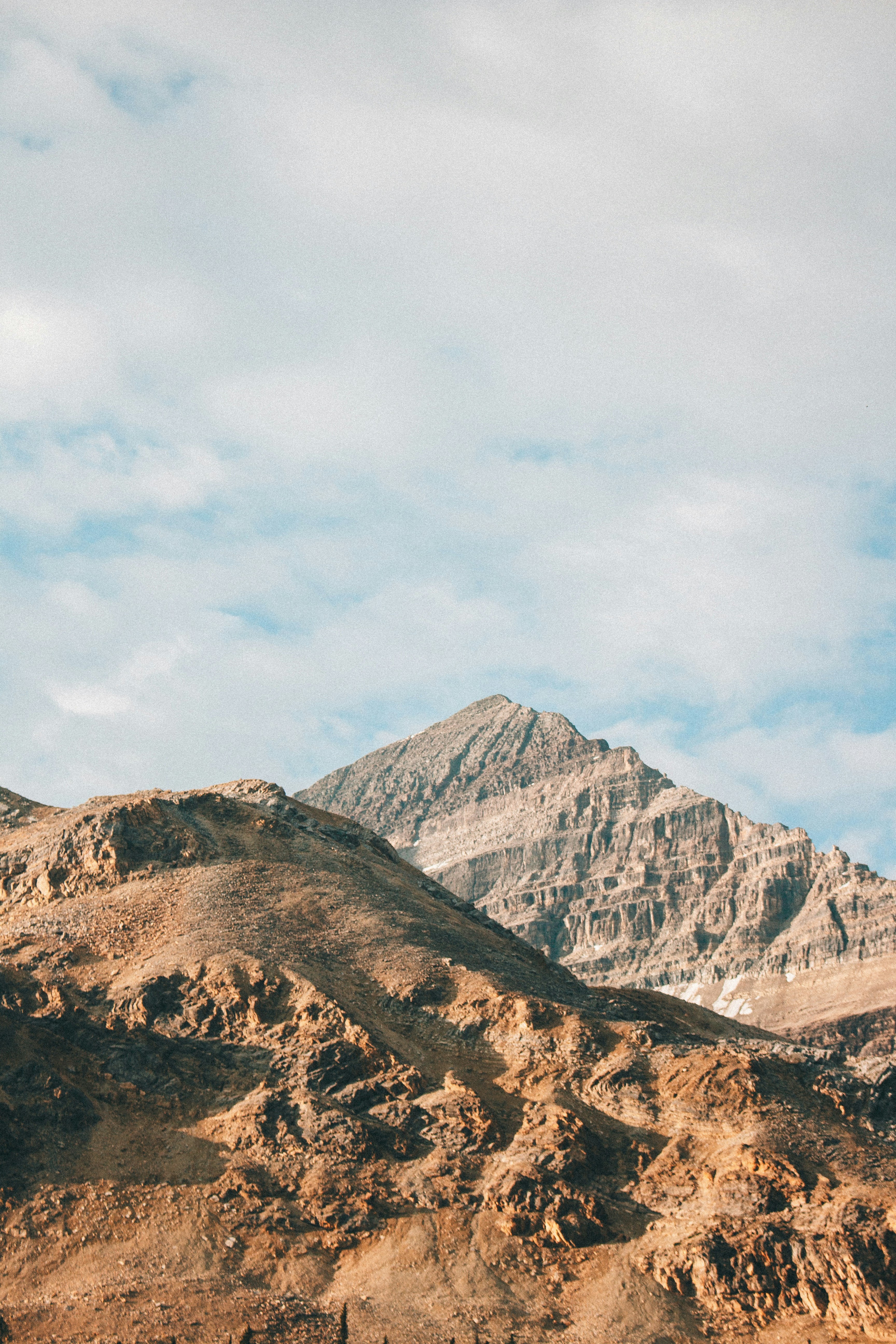 A view of a mountain range with a few clouds in the sky photo – Free ...