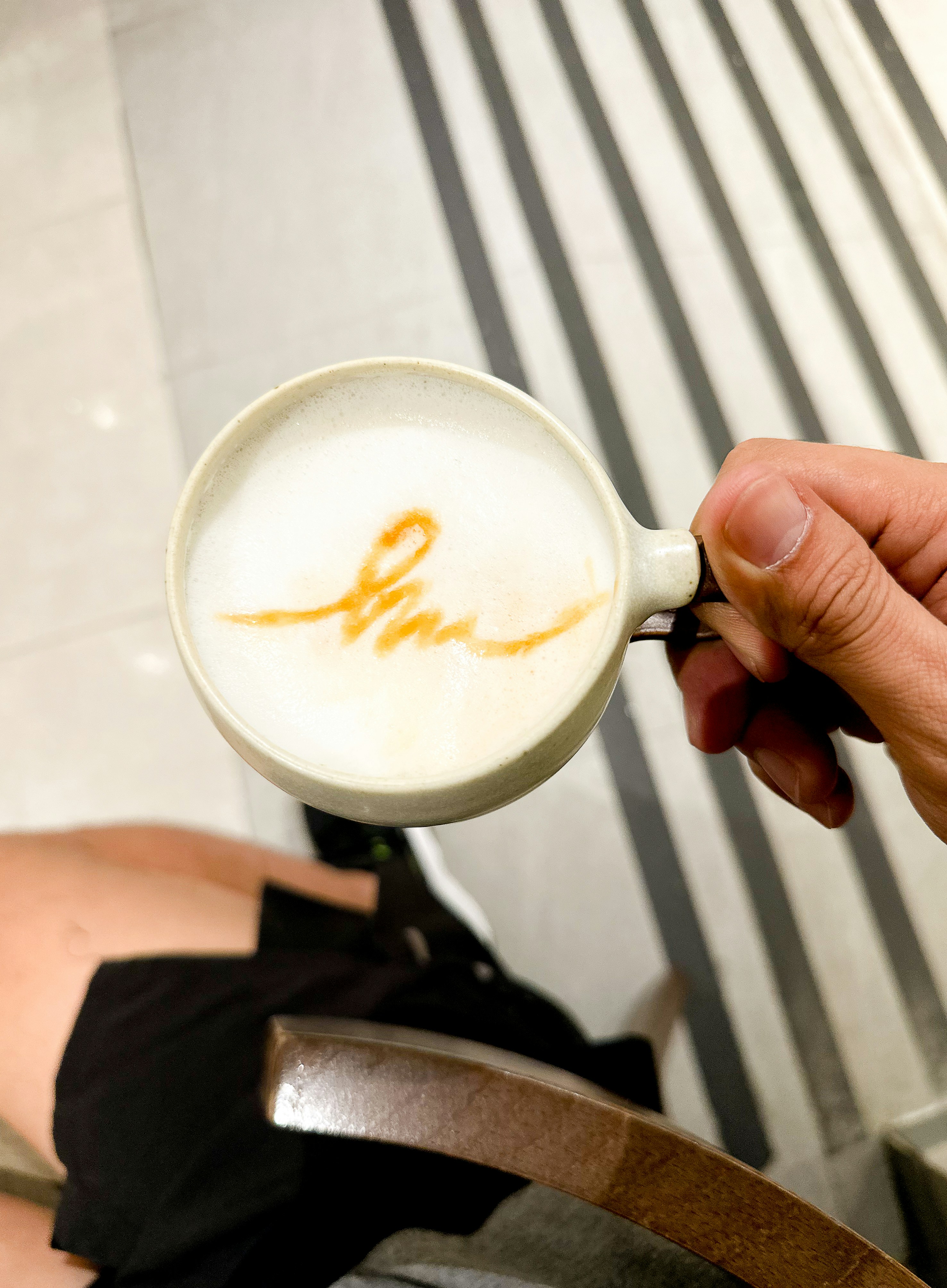 Caramel Script on Foam: A Hand-Held Latte from Above