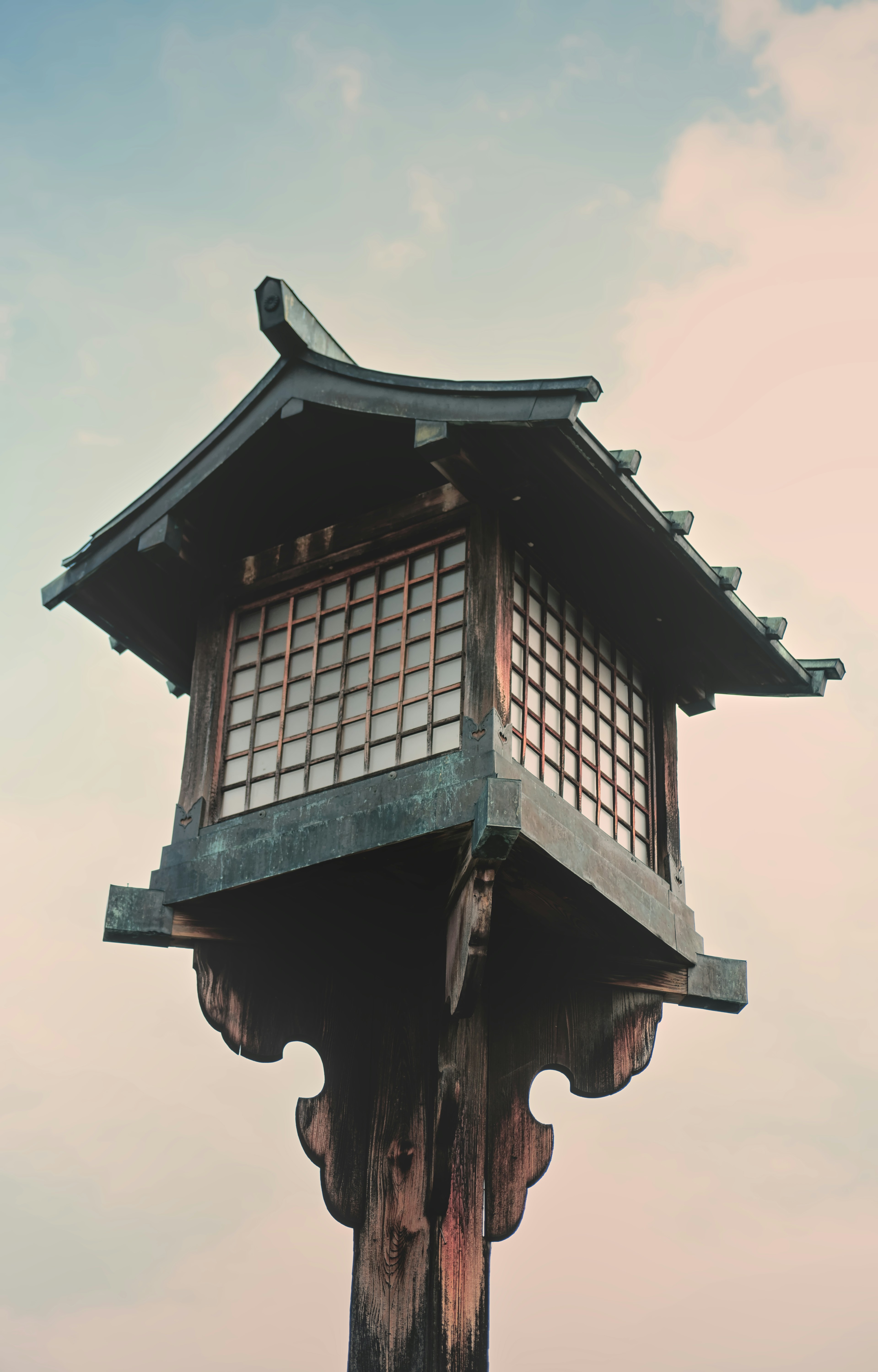 Carved Lantern Stand at Dusk Under a Peach-Sky