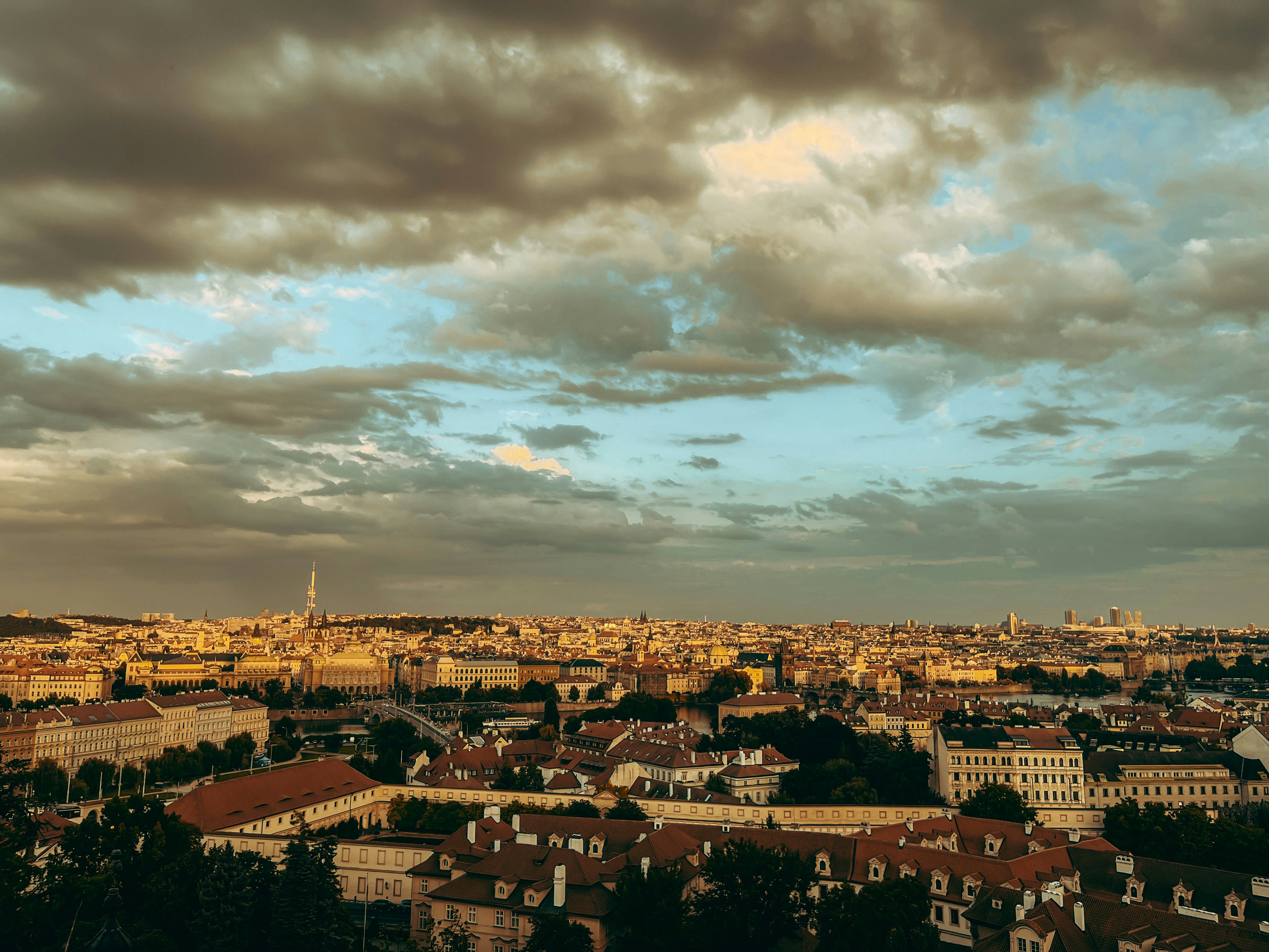 City skyline at sunset under dramatic clouds.