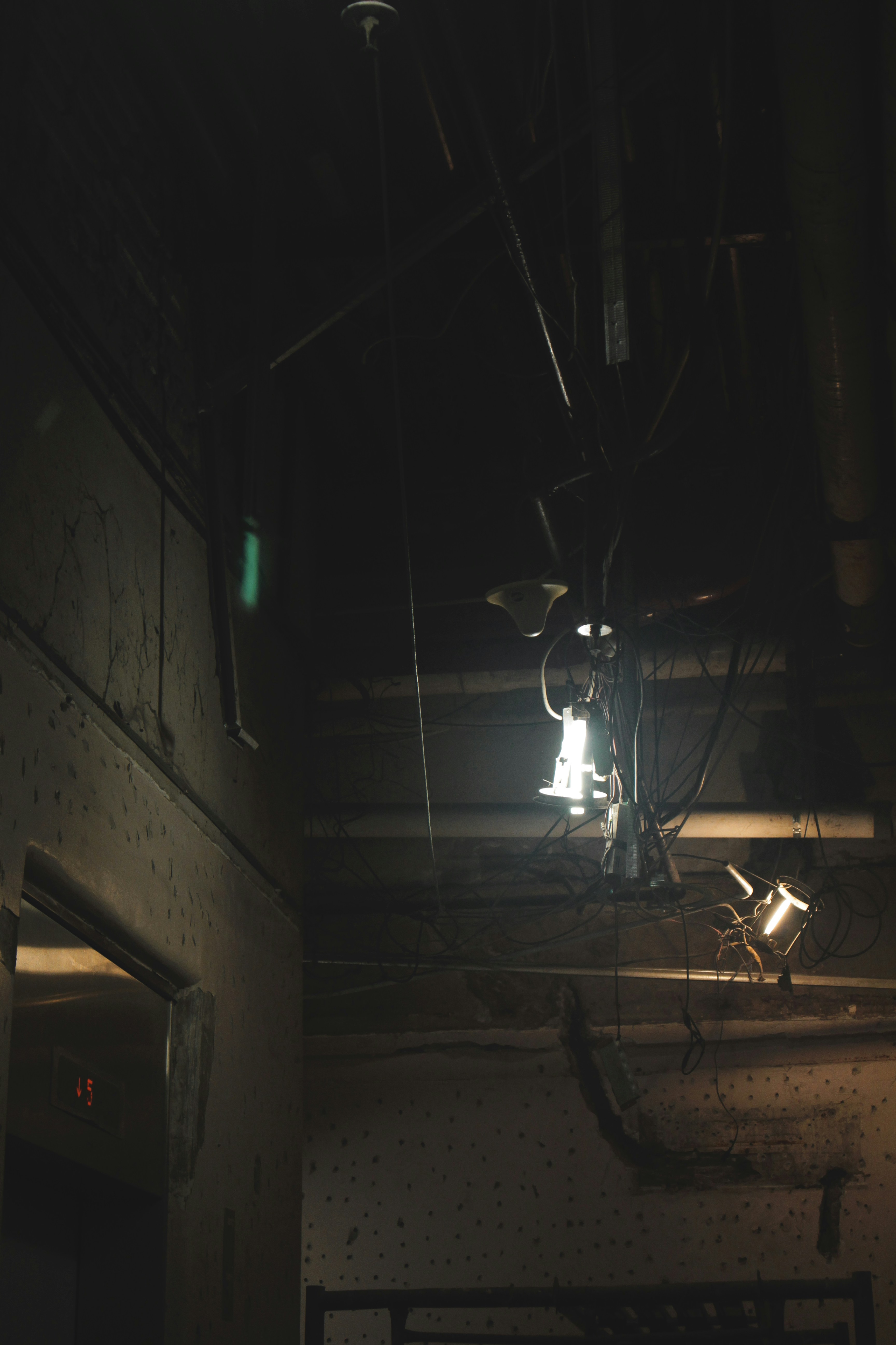 A dimly lit room with exposed pipes and lights photo – Free Free stock ...