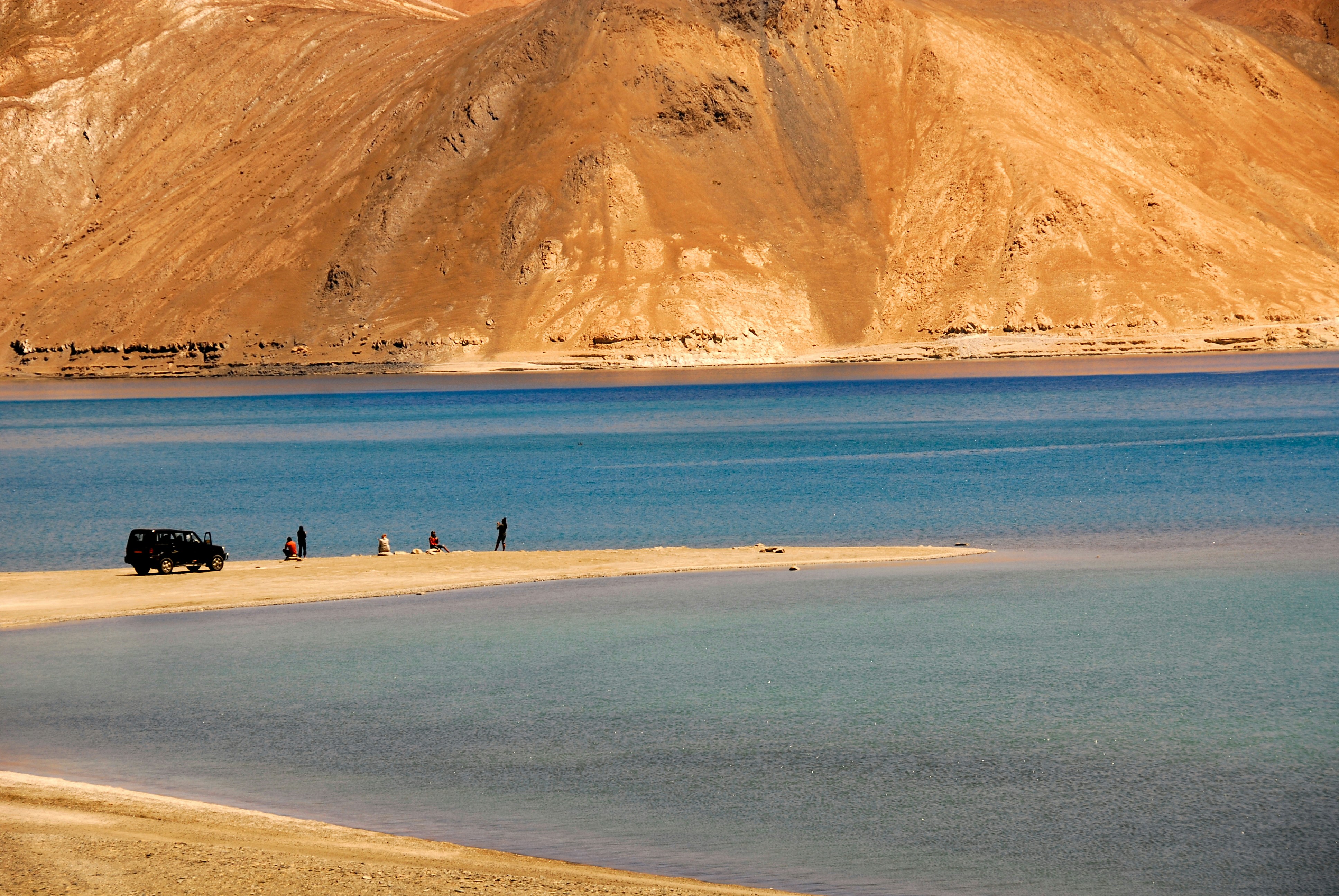 Desert-Hued Peaks Guard a Narrow Sandbar Along Turquoise Waters