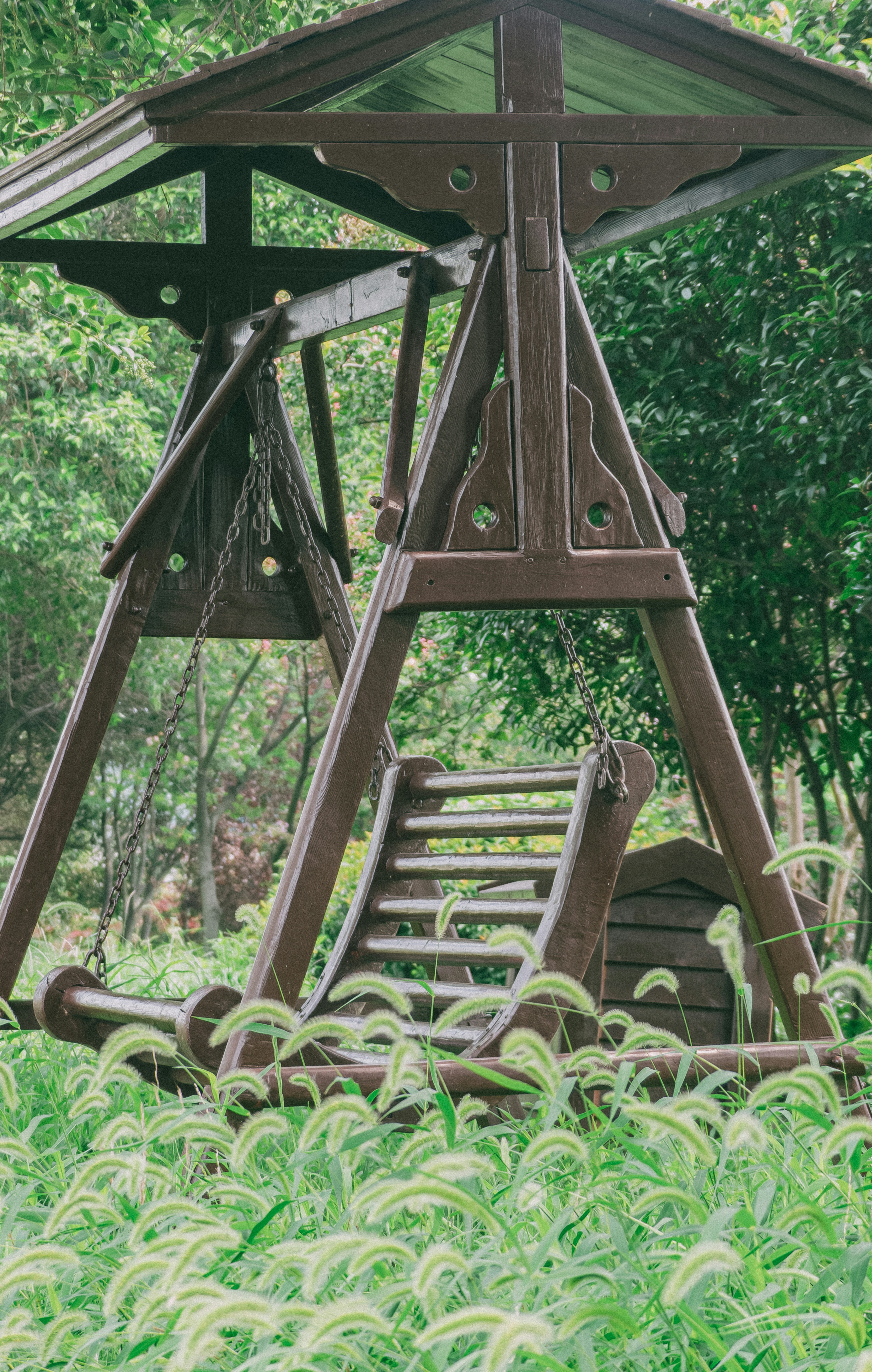 Wooden Playground Swing Frame Surrounded by Spring Greenery