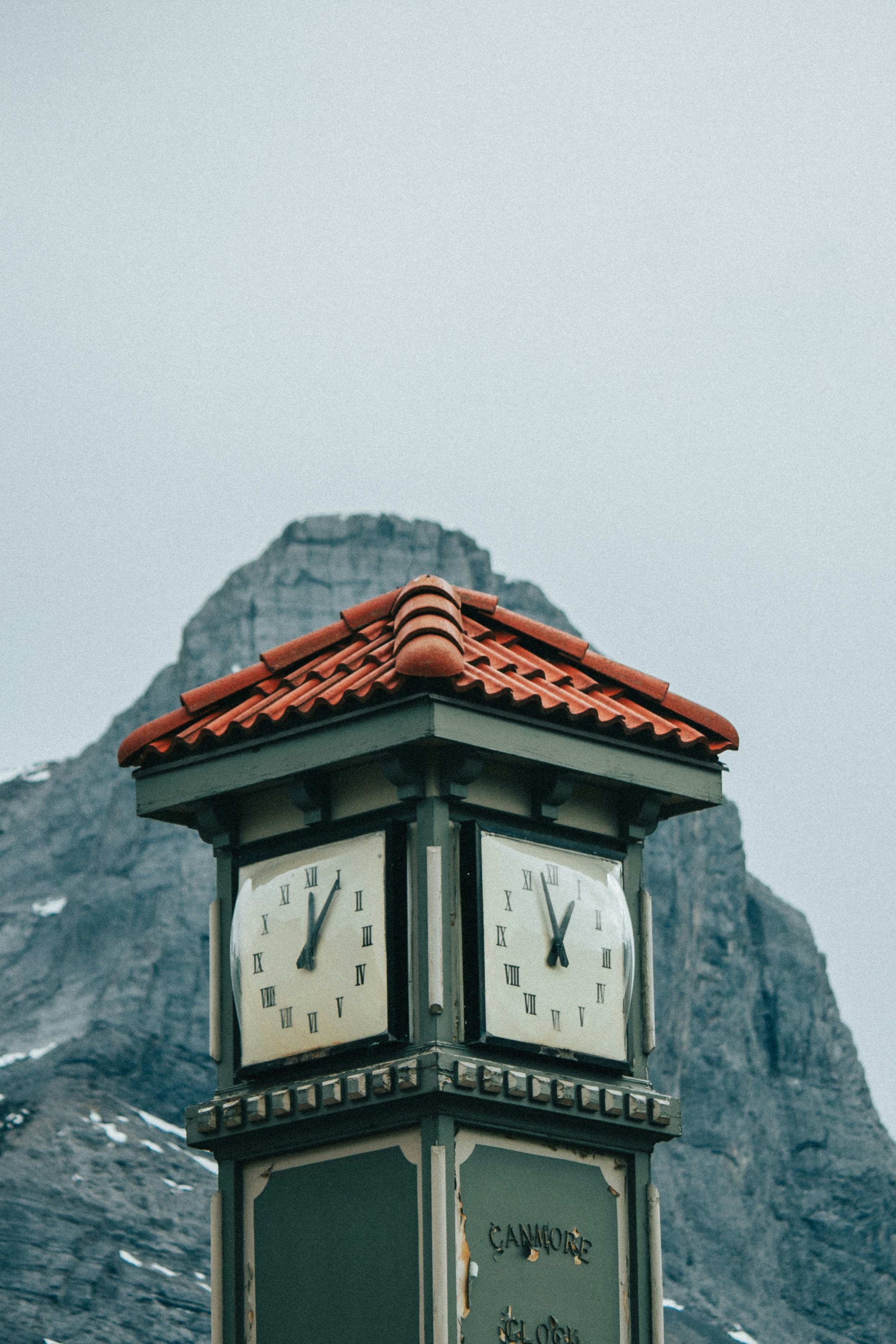Twin-Dial Clock Tower Framed by Alpine Backdrop