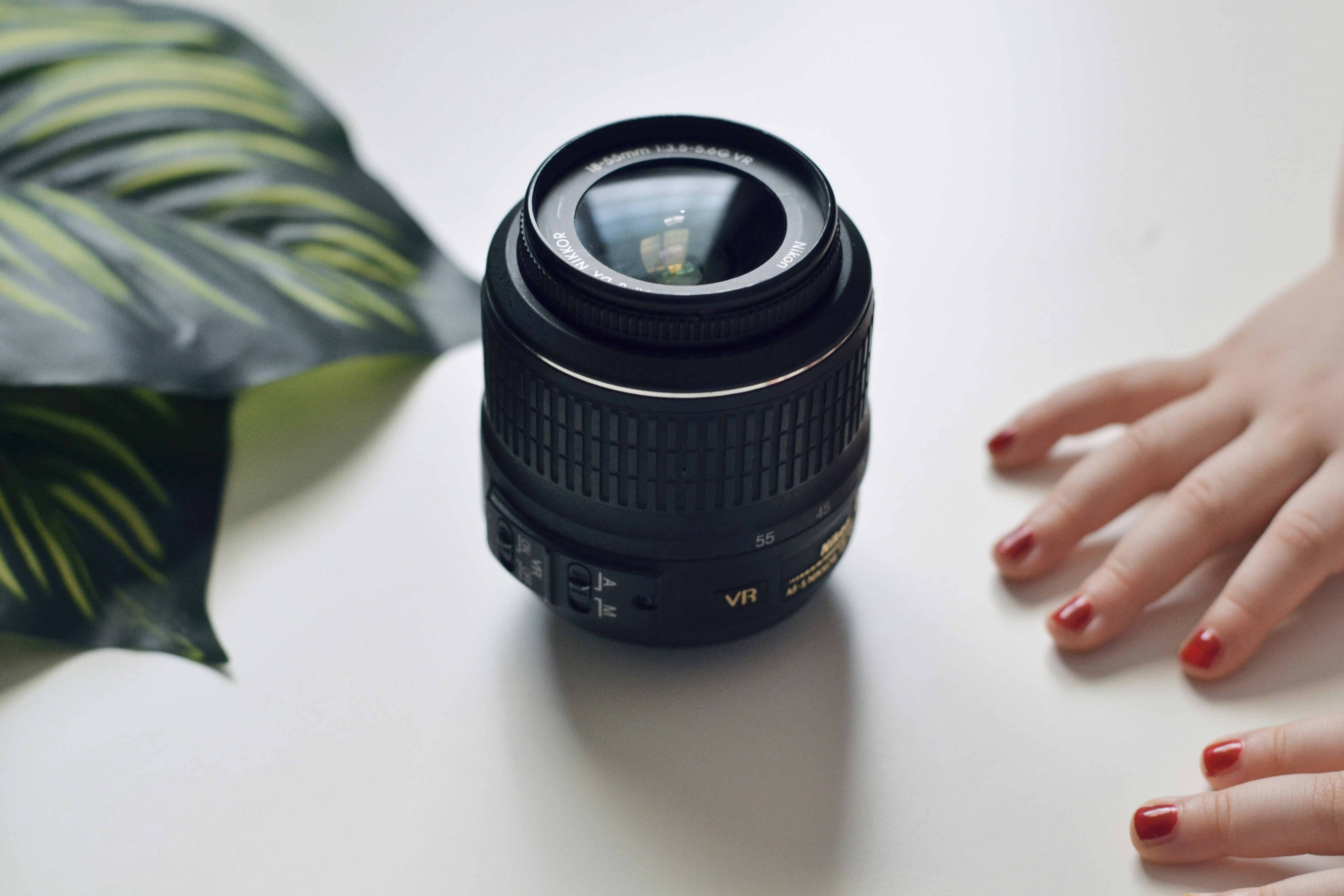 A Quiet Close-Up: The Nikon Lens Resting on a Minimal Desk