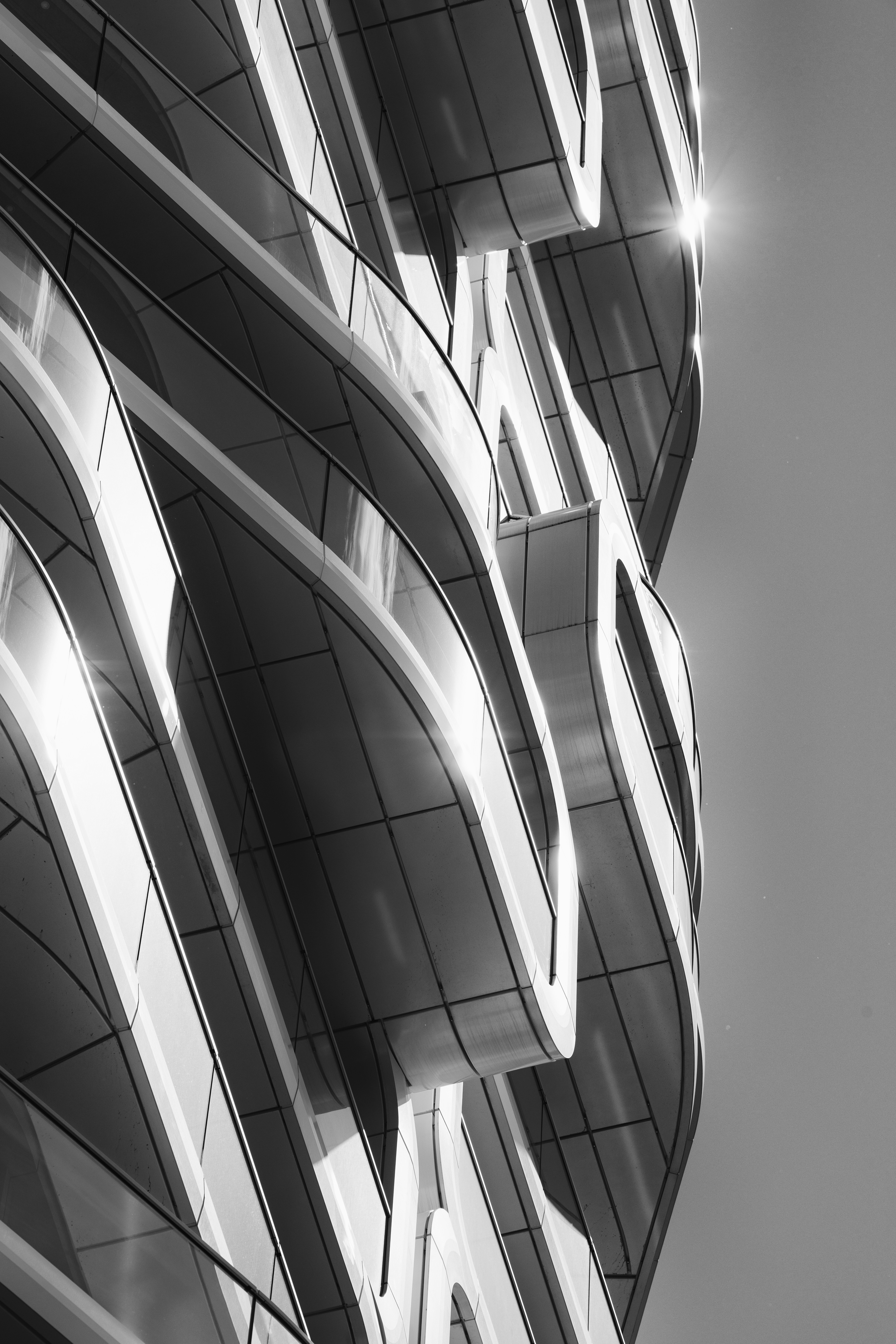 Ribbons of Glass: A Sunlit Curved Facade in Monochrome