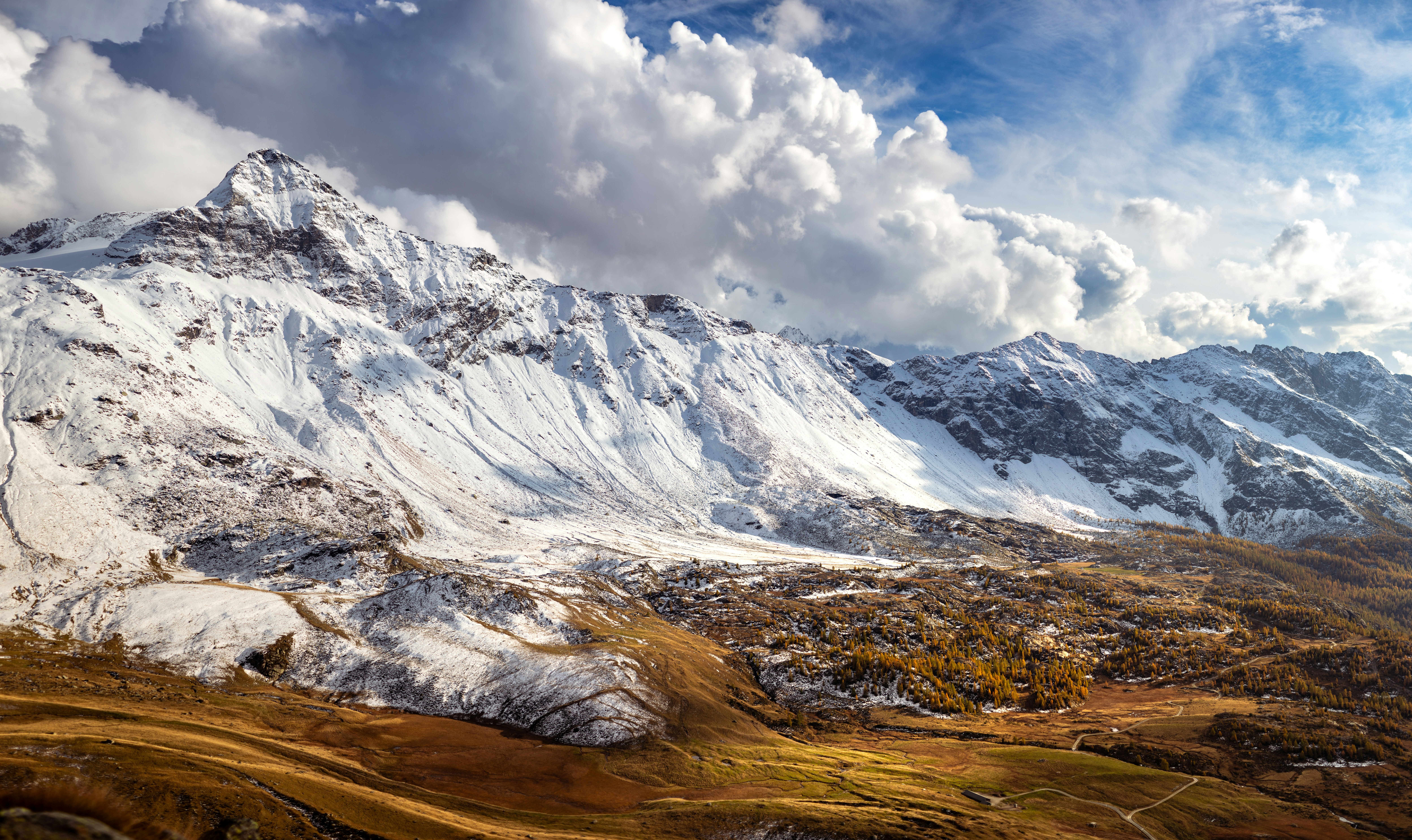 A snow covered mountain range under a partly cloudy sky photo – Free ...