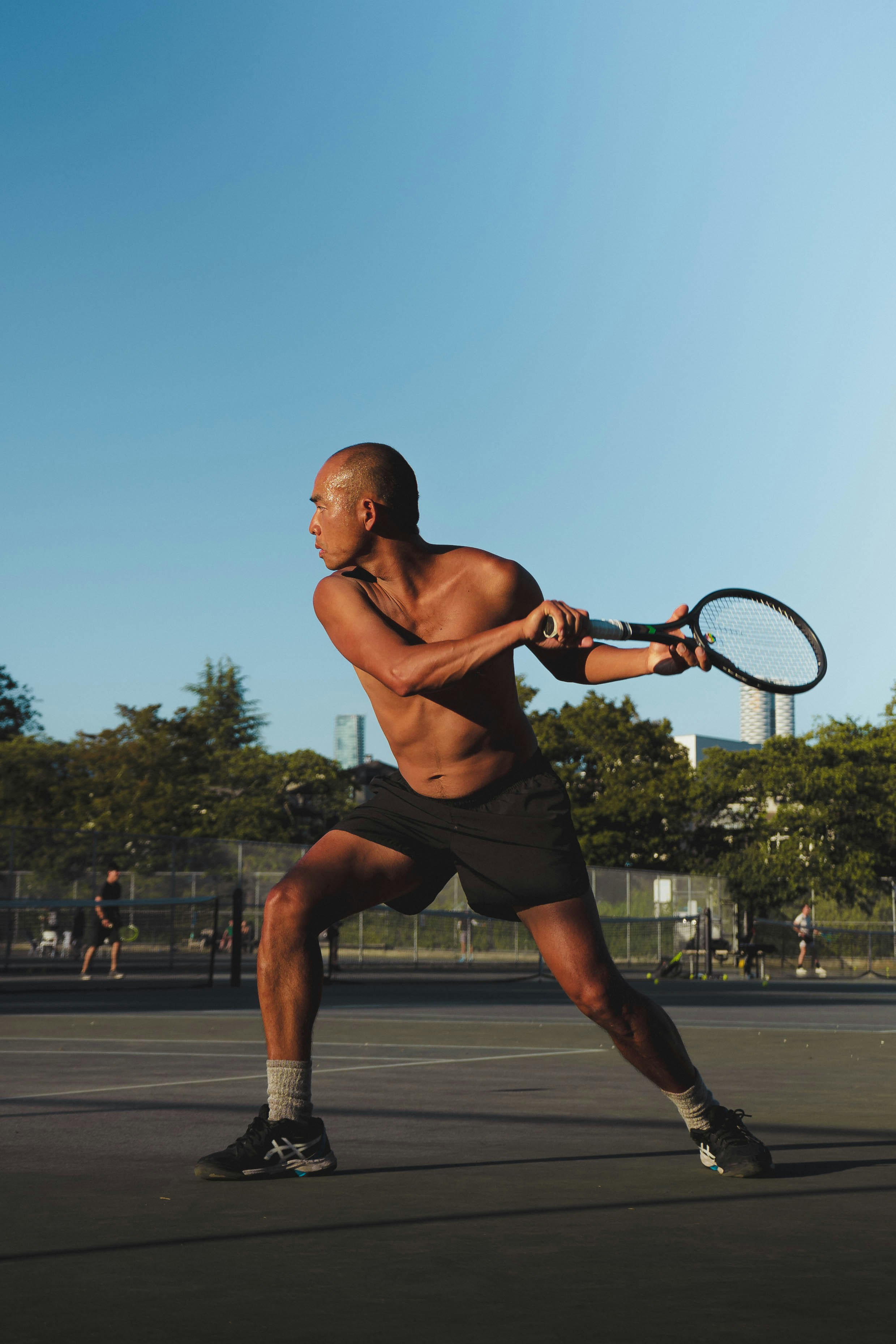 A man holding a tennis racquet on top of a tennis court photo – Free ...