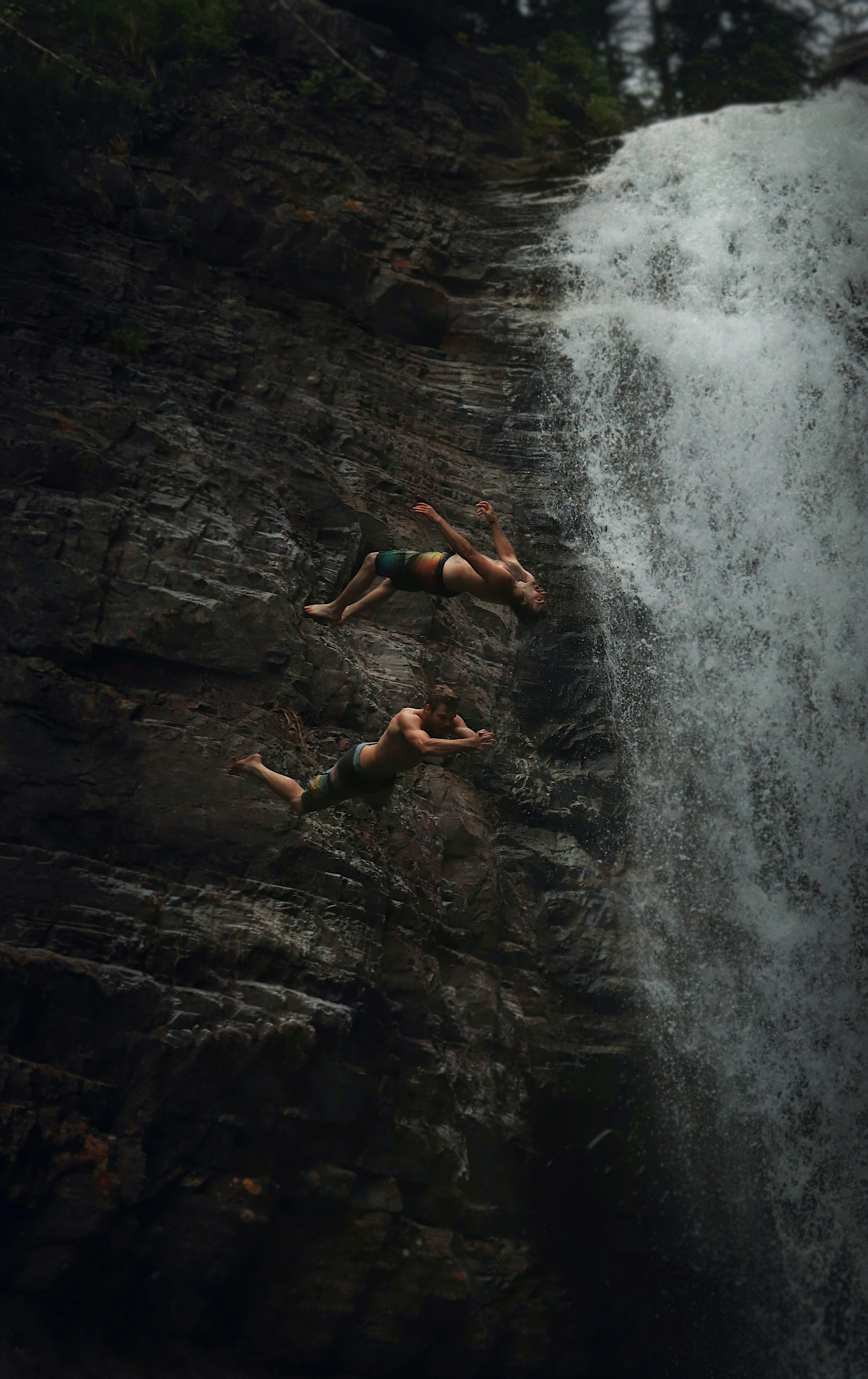 Duel on the Drop: Twin Cliff Divers Leaping by a Thunderous Waterfall