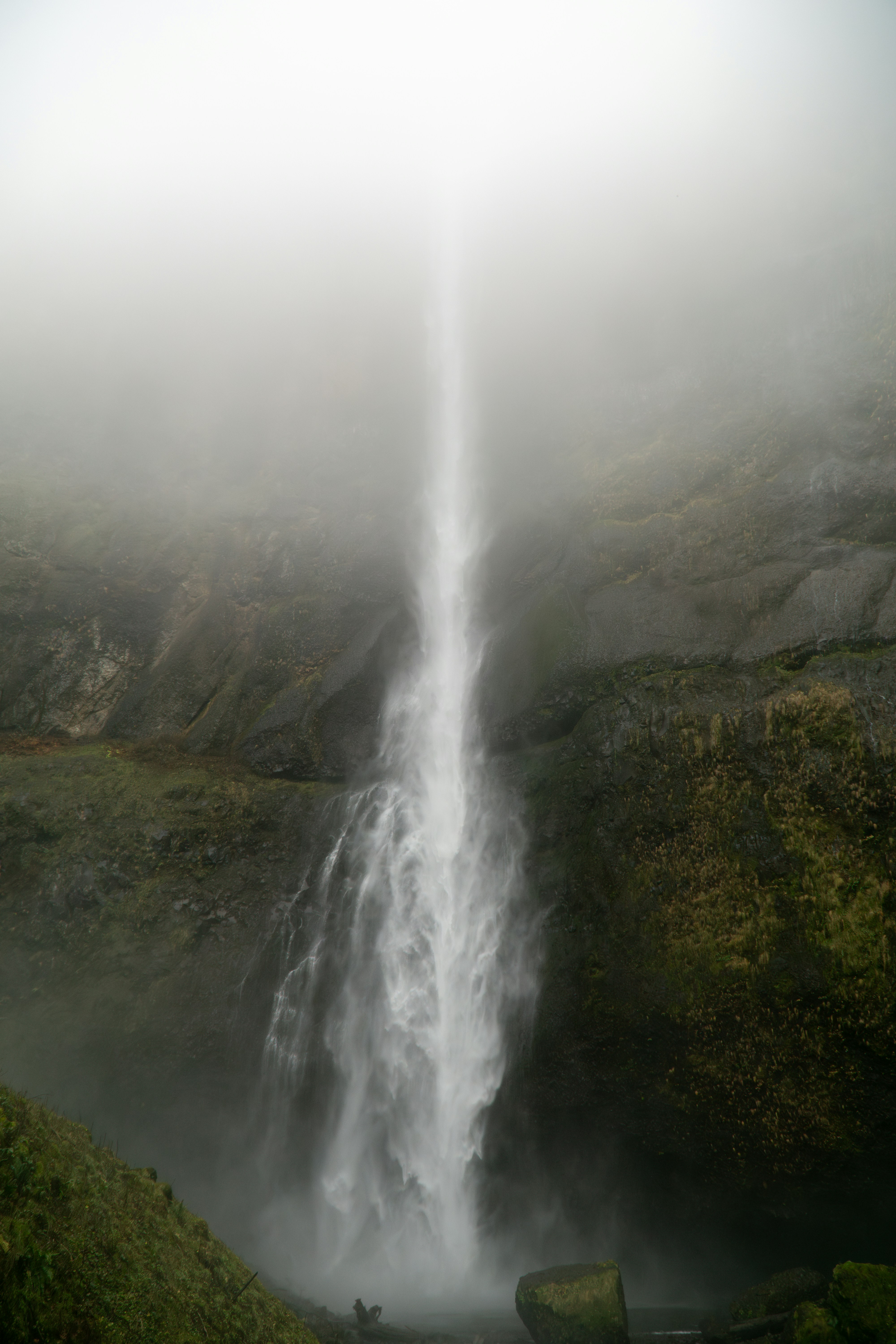 A very tall waterfall in the middle of a lush green field photo – Free ...