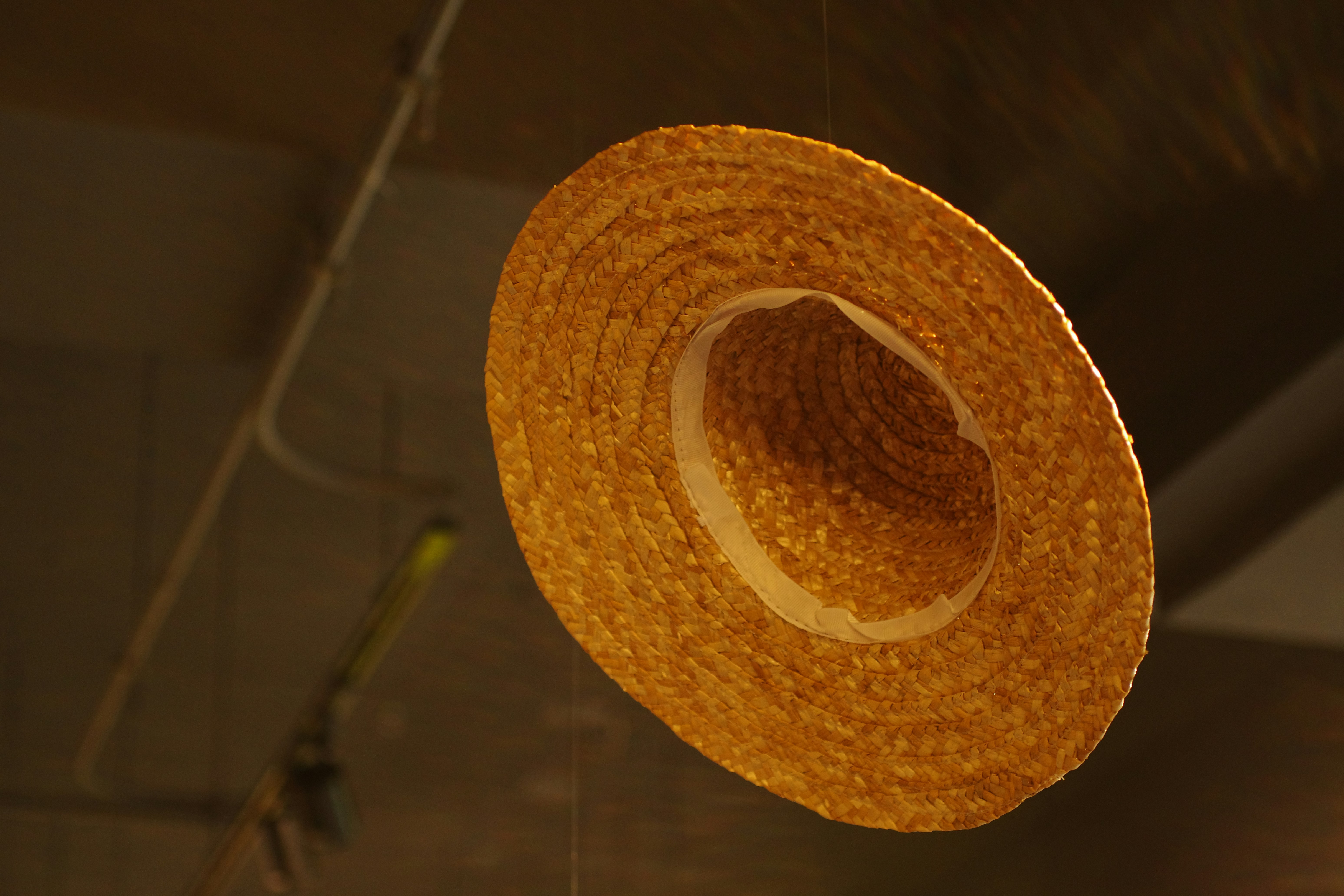 Suspended Straw Hat in Warm Studio Light