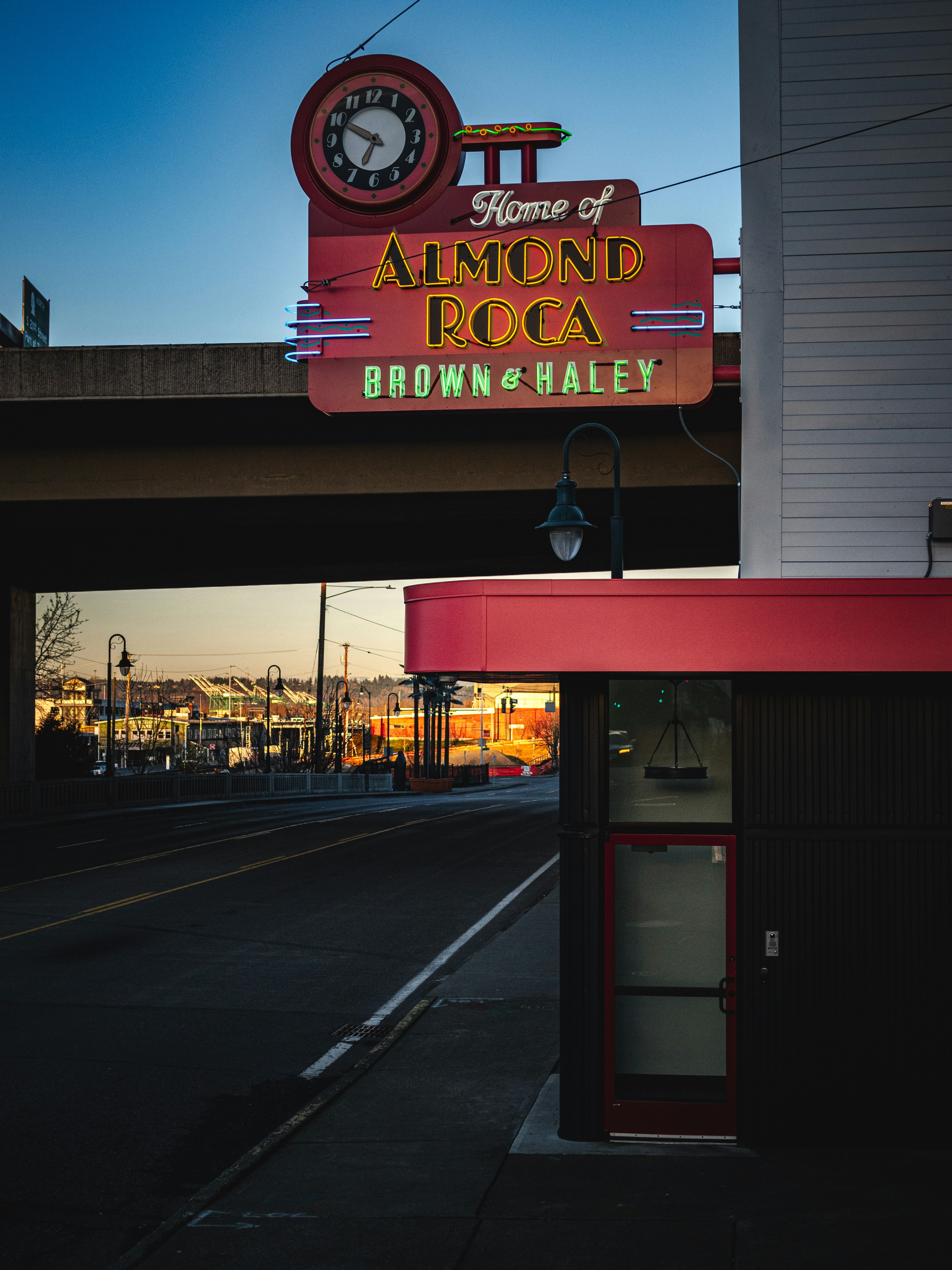 Clock, Neon, and Almond Roca: A Retro Sign Above a Quiet Downtown