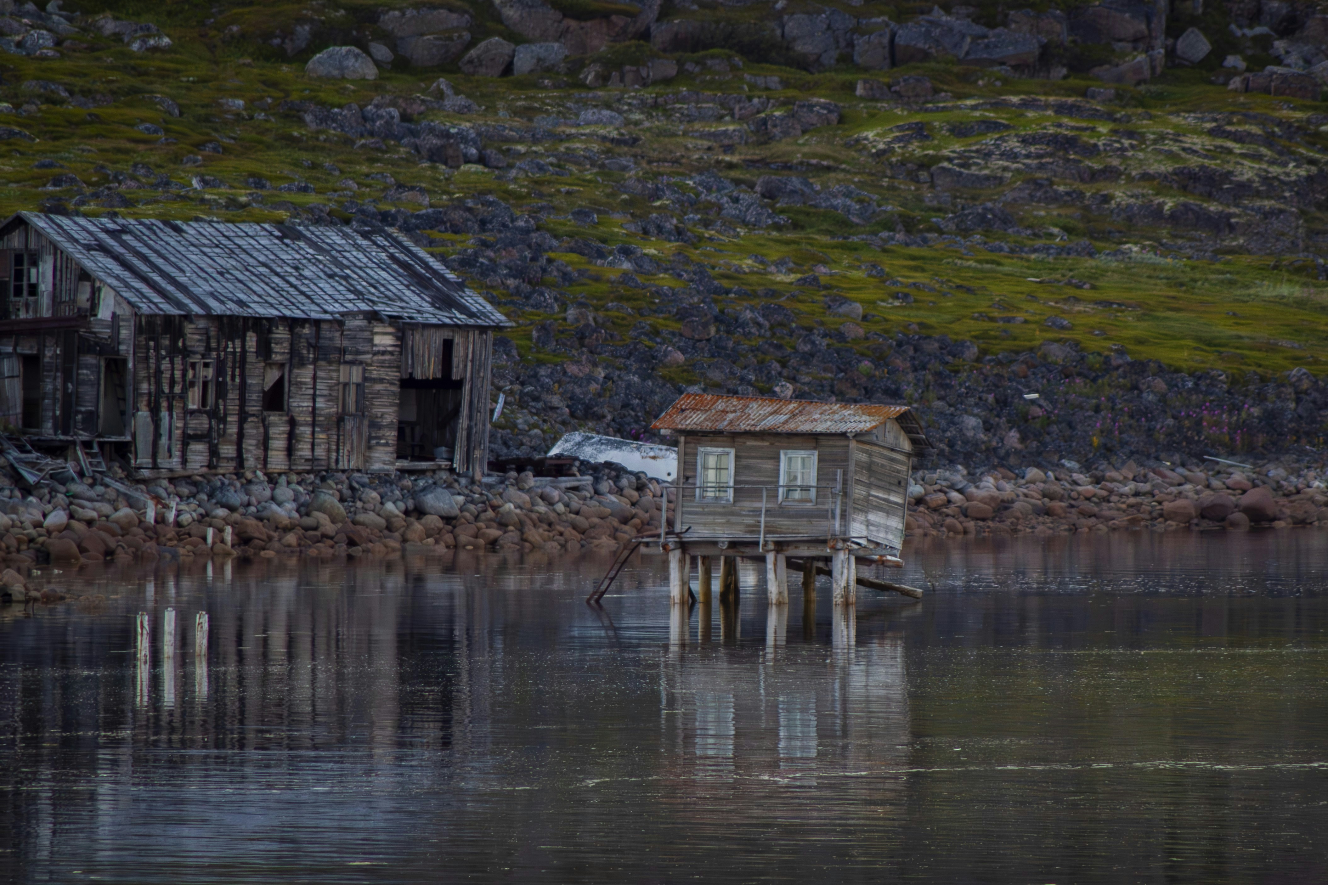 An old shack sitting in the middle of a lake photo – Free Sea Image on ...