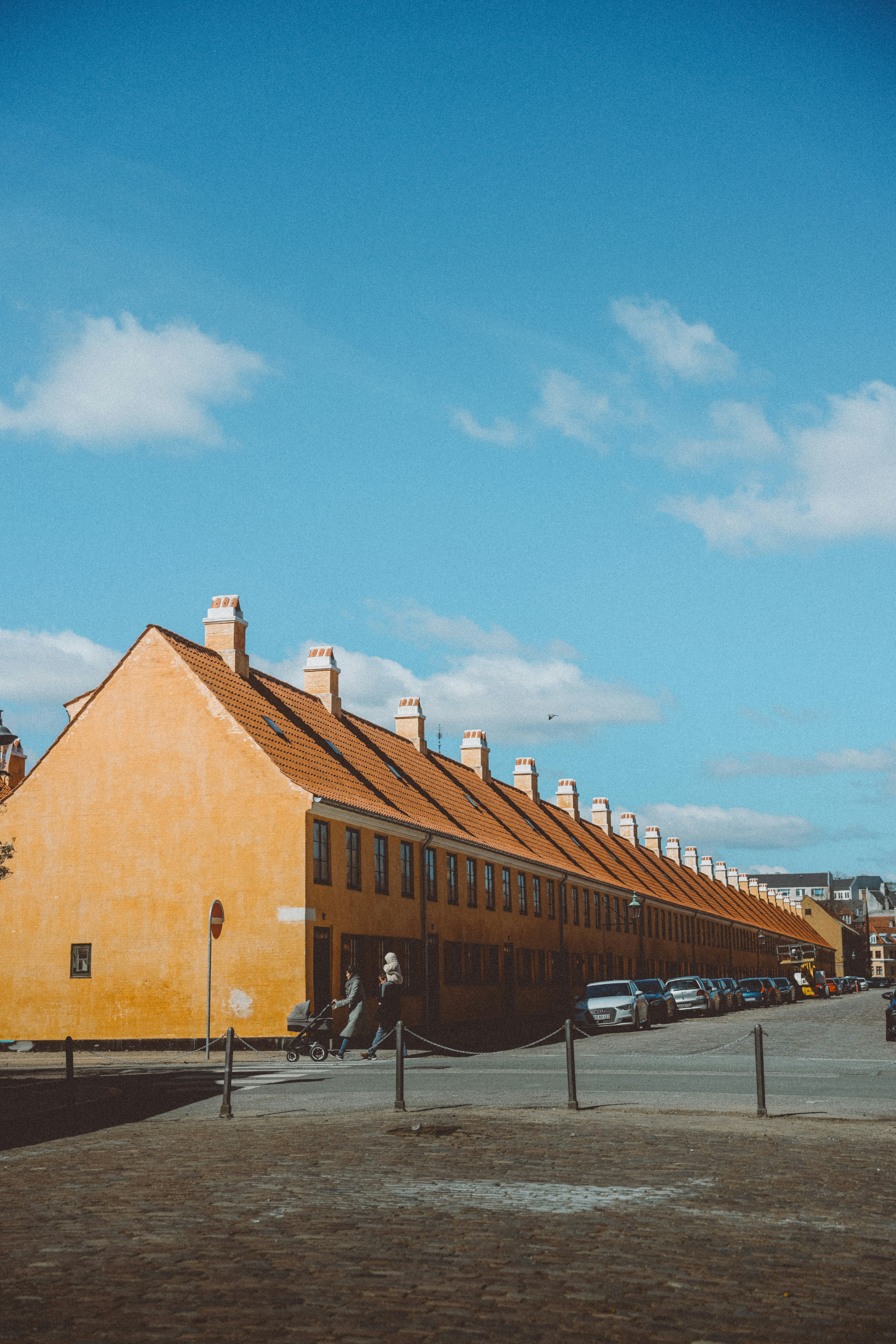 Row of Sunlit Townhouses: A Golden Street Under a Clear Sky