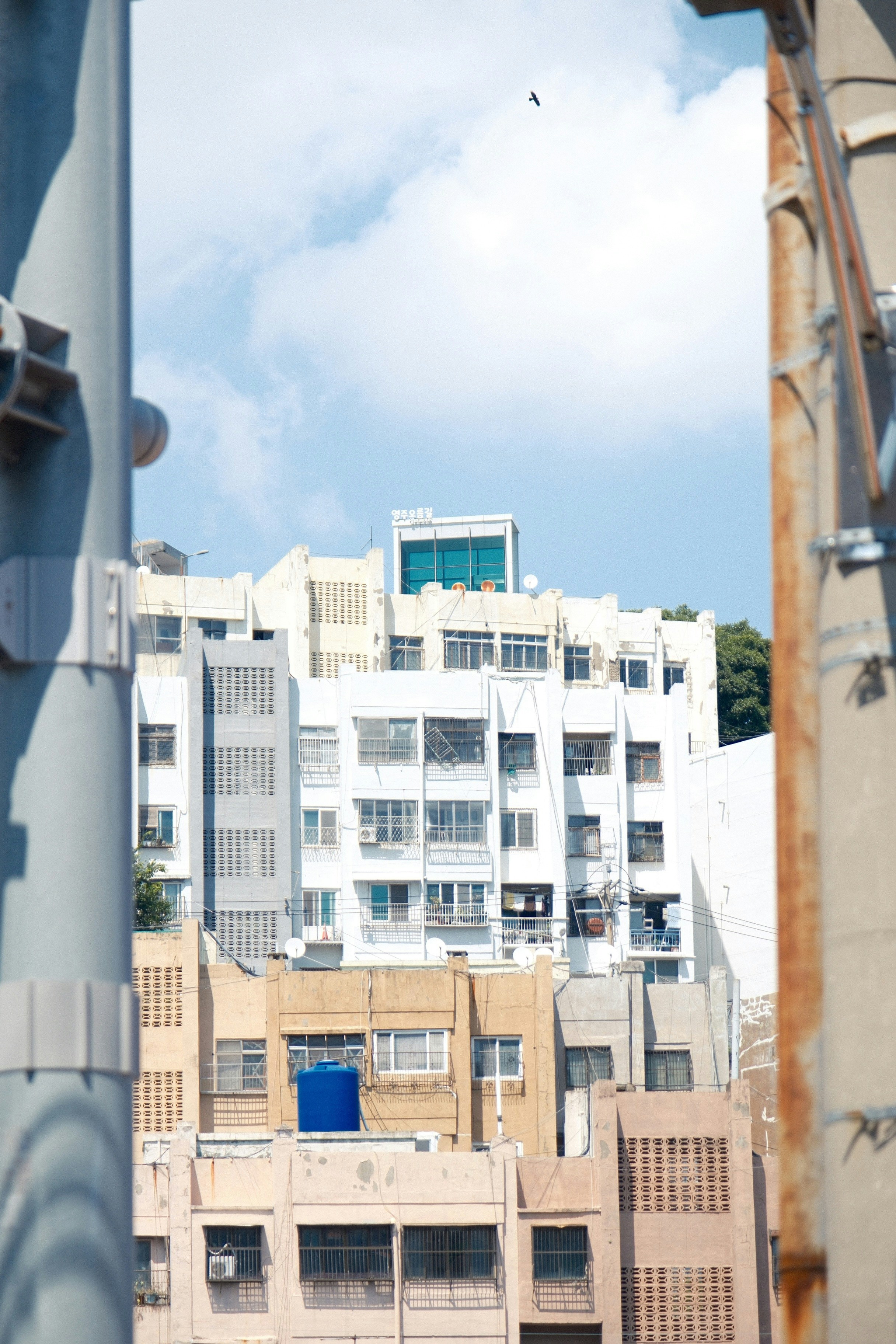Narrow Urban Vista: White Facades Rising Under a Clear Sky
