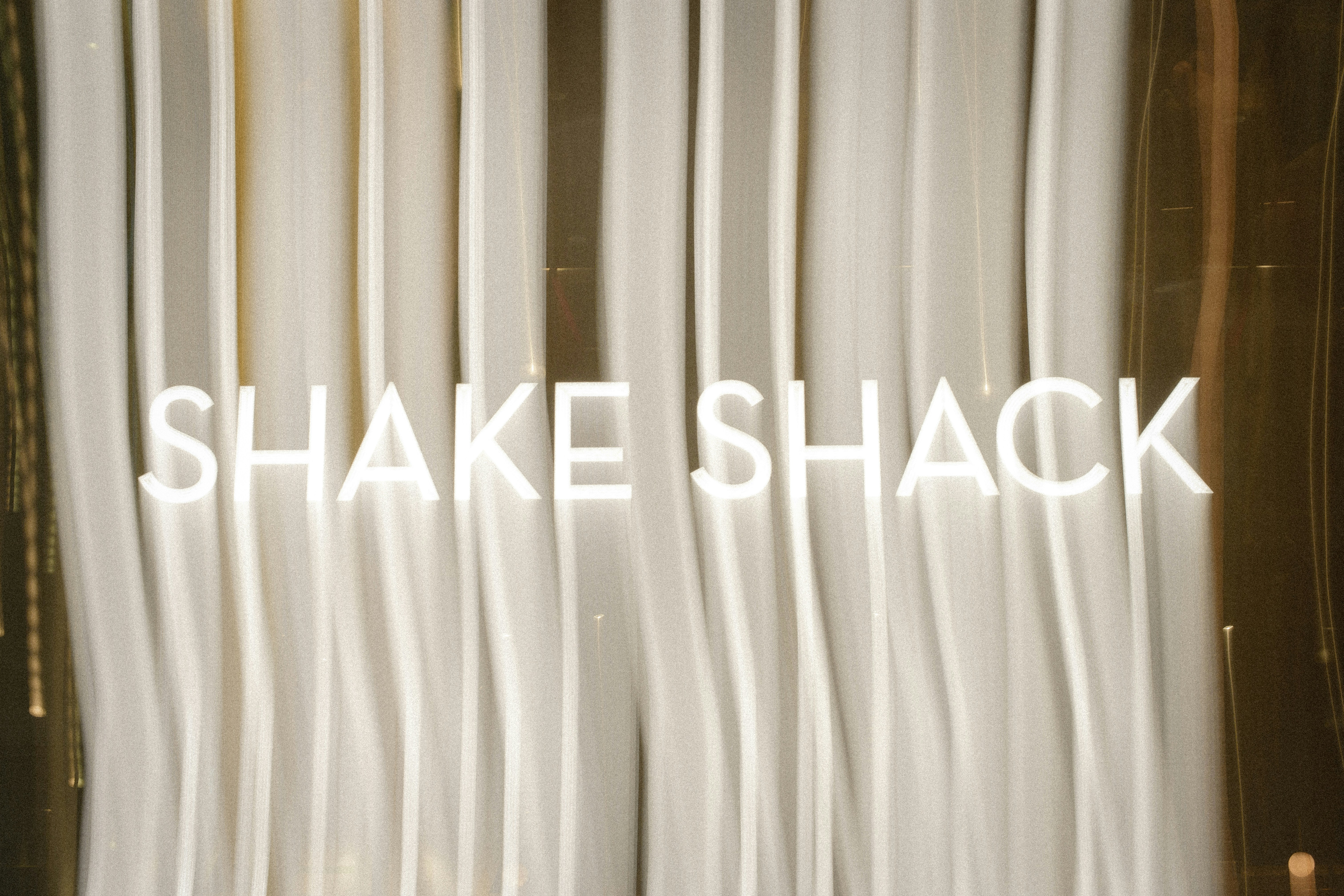 A close up of a white curtain with the words shake shack on it photo ...