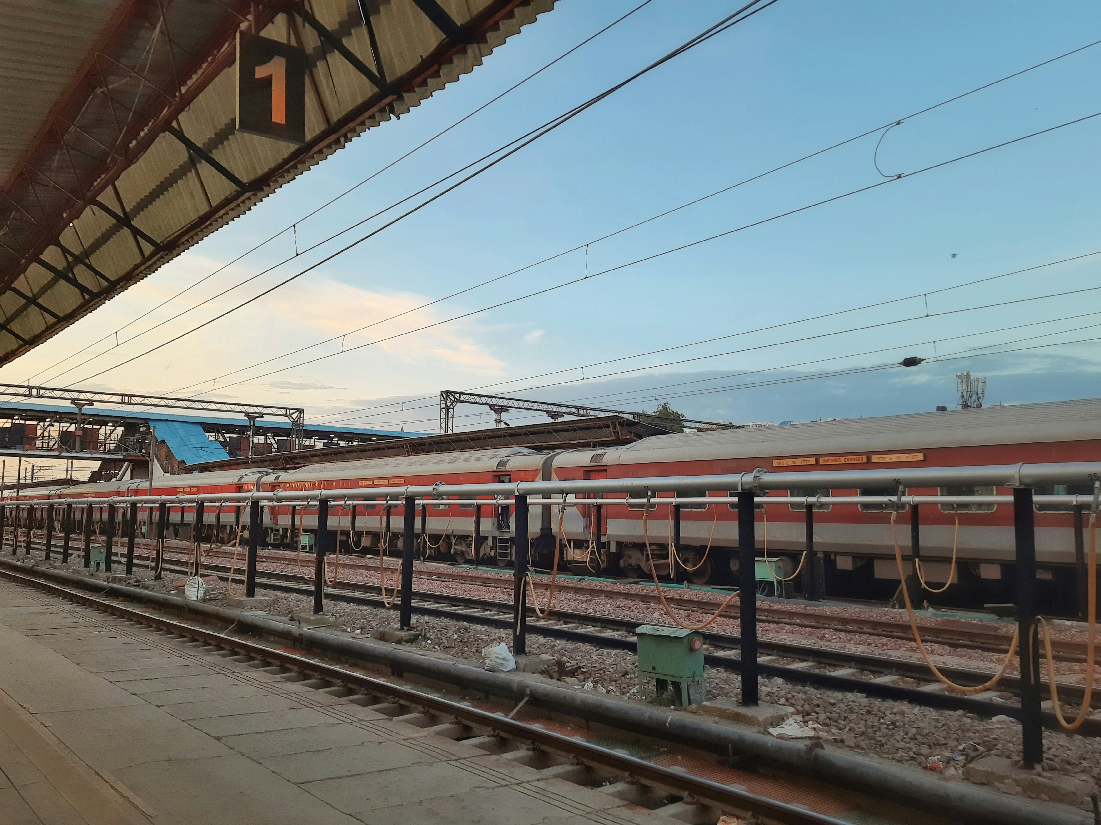 Sunset Rails: Platform Lines Framed by a Red-White Train