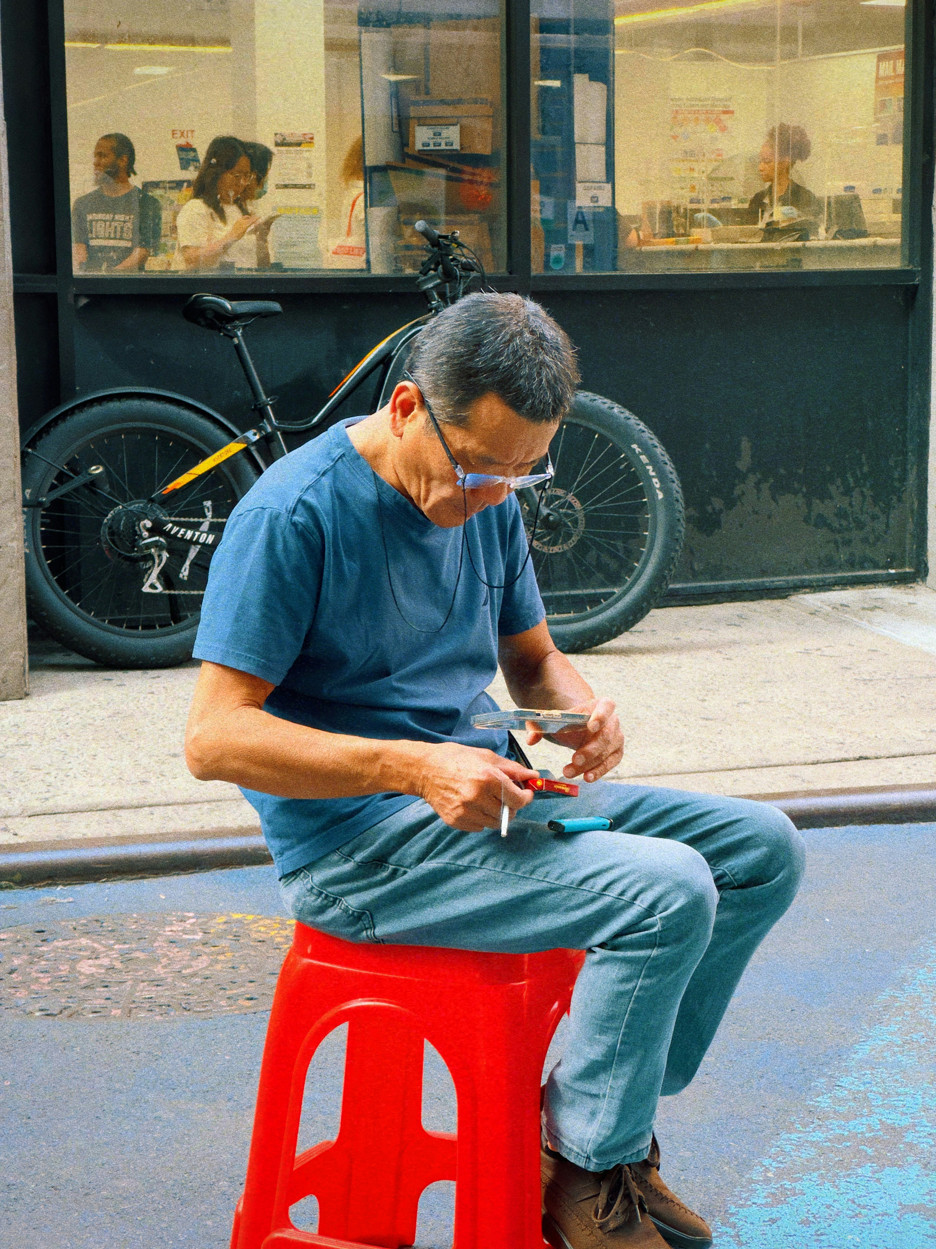 Blue Shirt, Red Stool, and a Pocket of Focus: A City Pause