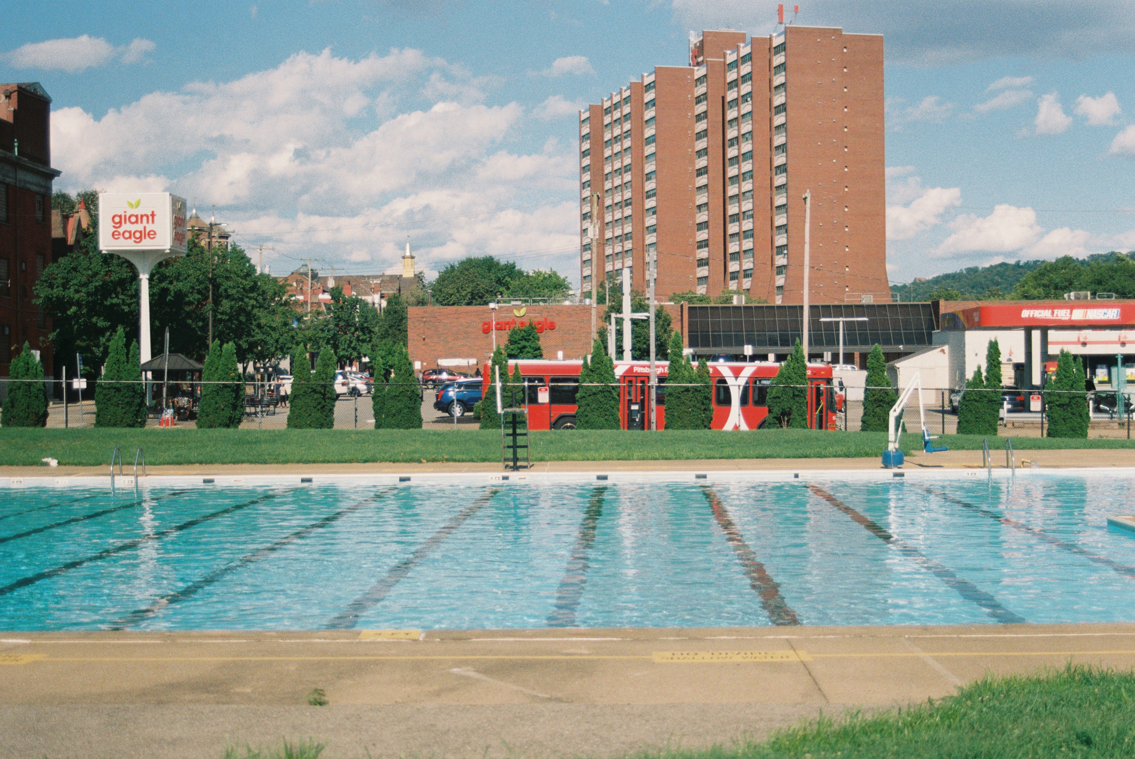 A large swimming pool in front of a tall building photo – Free ...