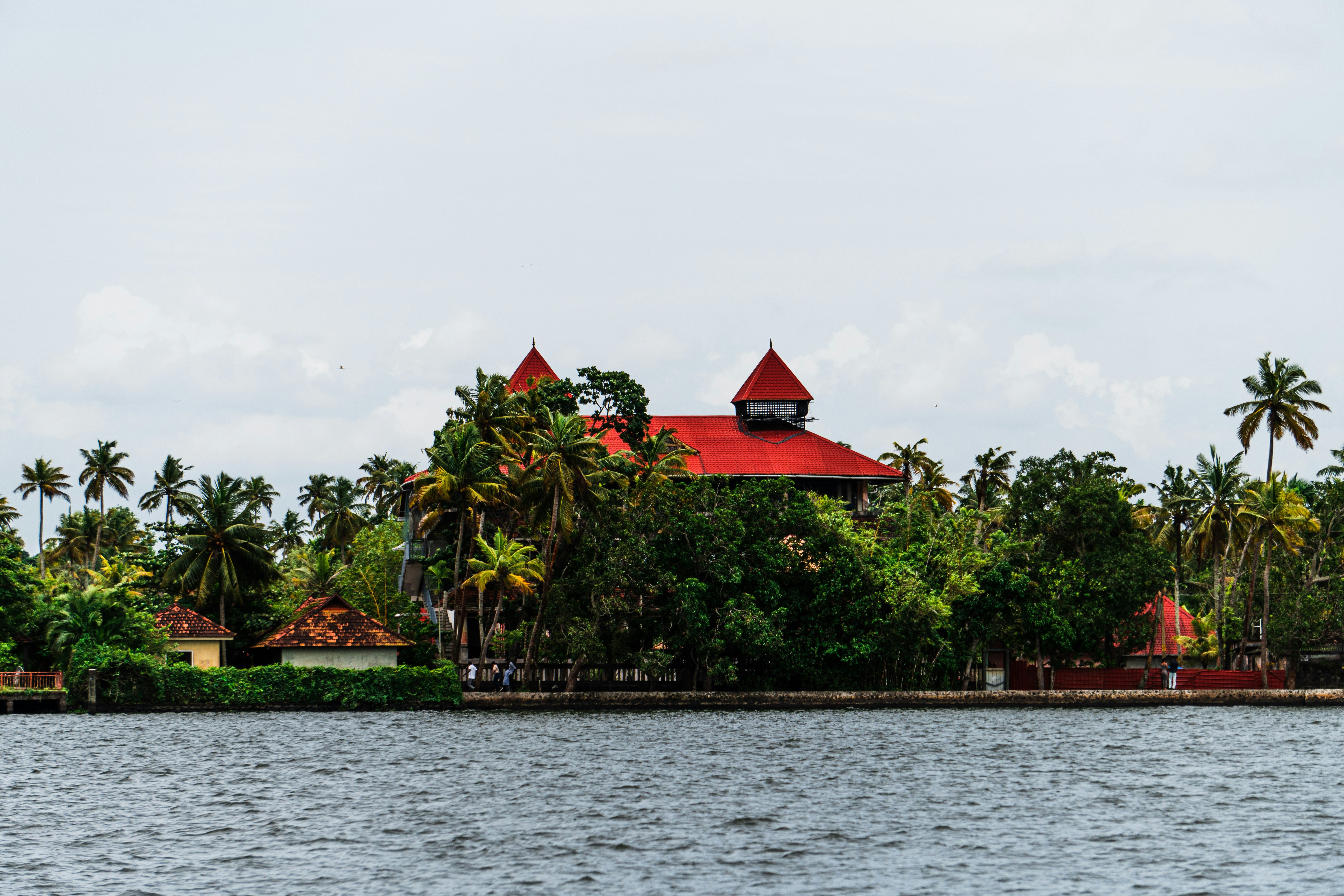 Red-Roofed Villa Framed by Tropical Canopy Along the Shore