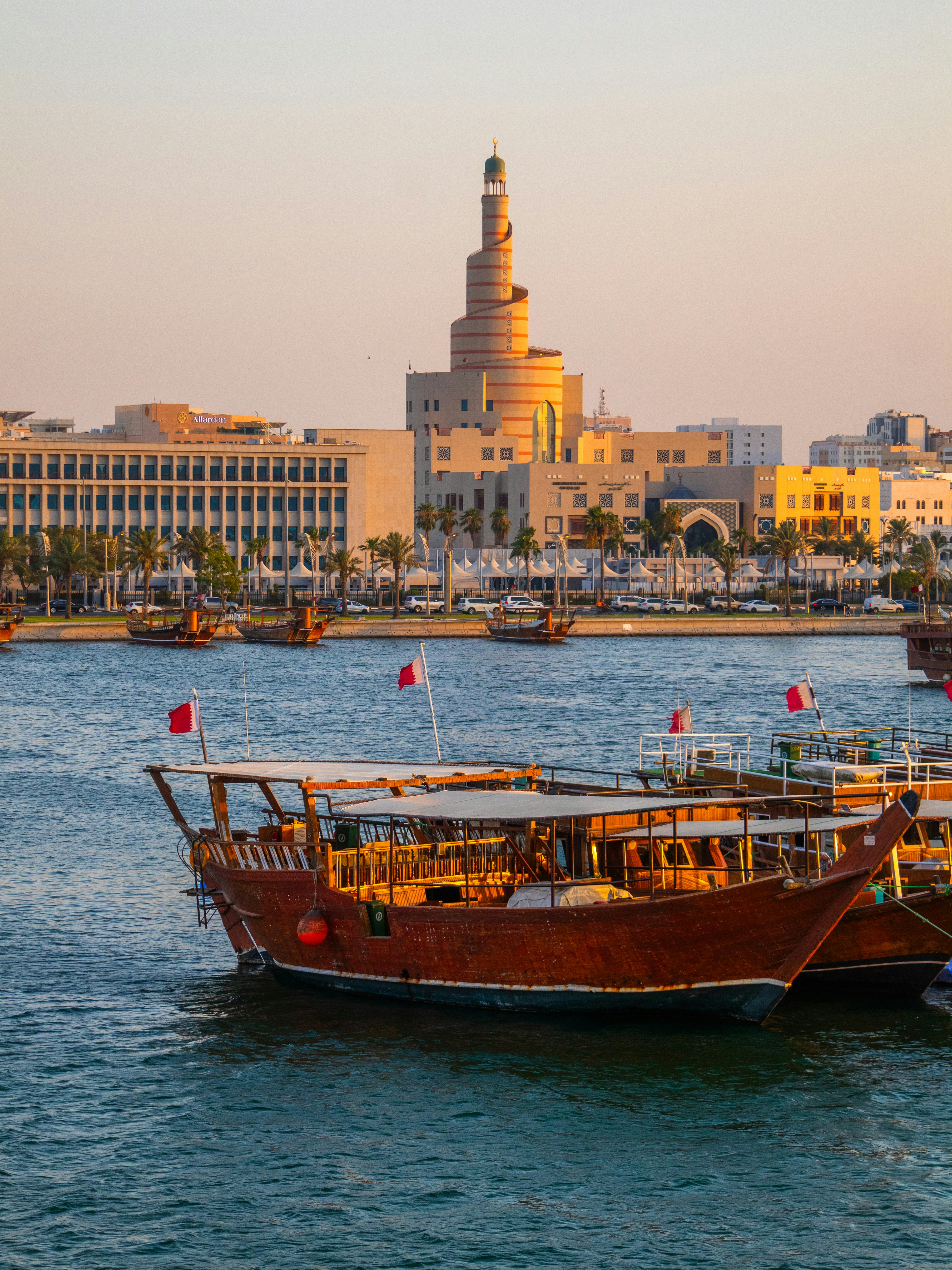 Spiral Beacon at Sunset: Dhows and a Harbor Skyline