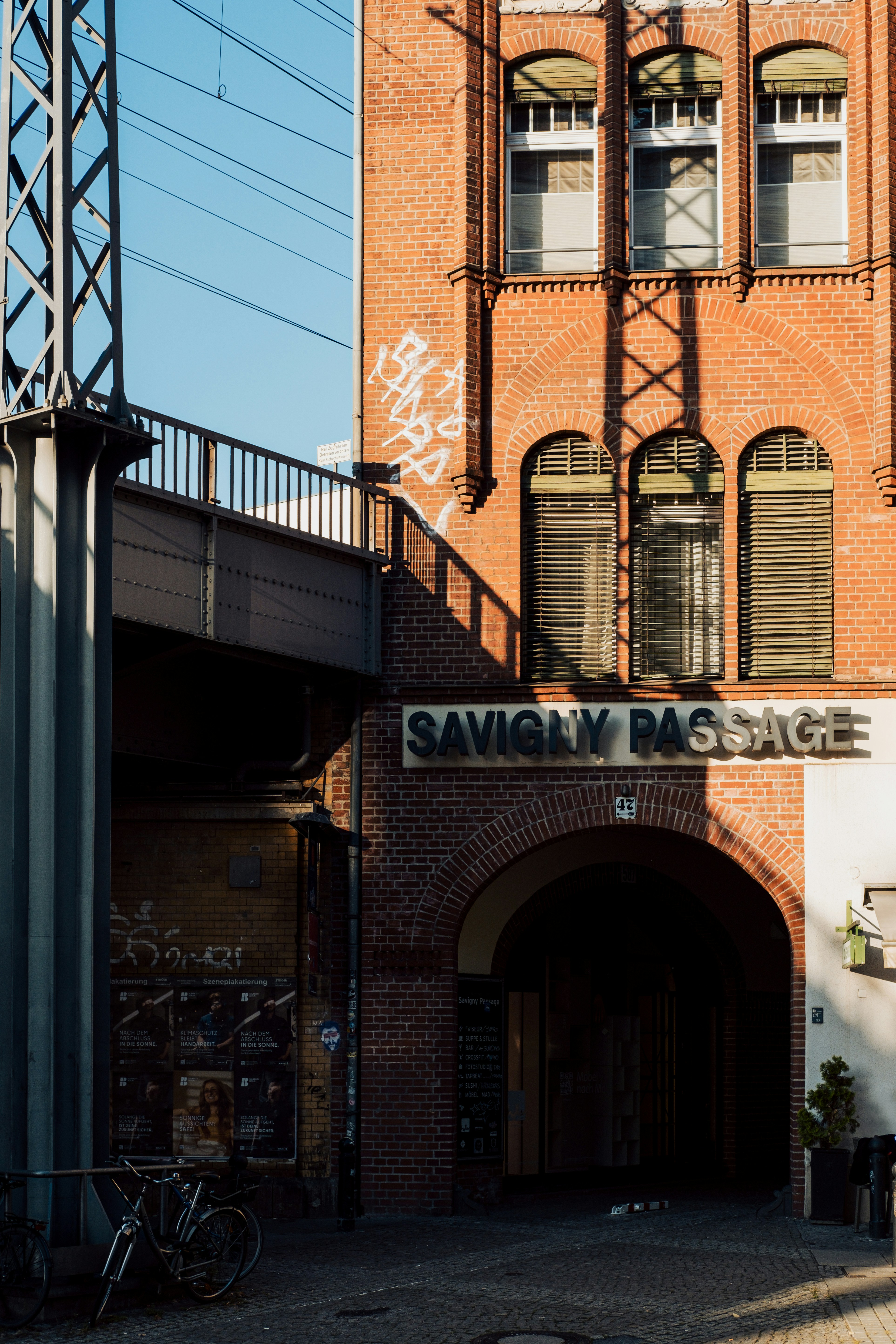 Savigny Passage in Sun: Arch, Graffiti, and Steel Shadows