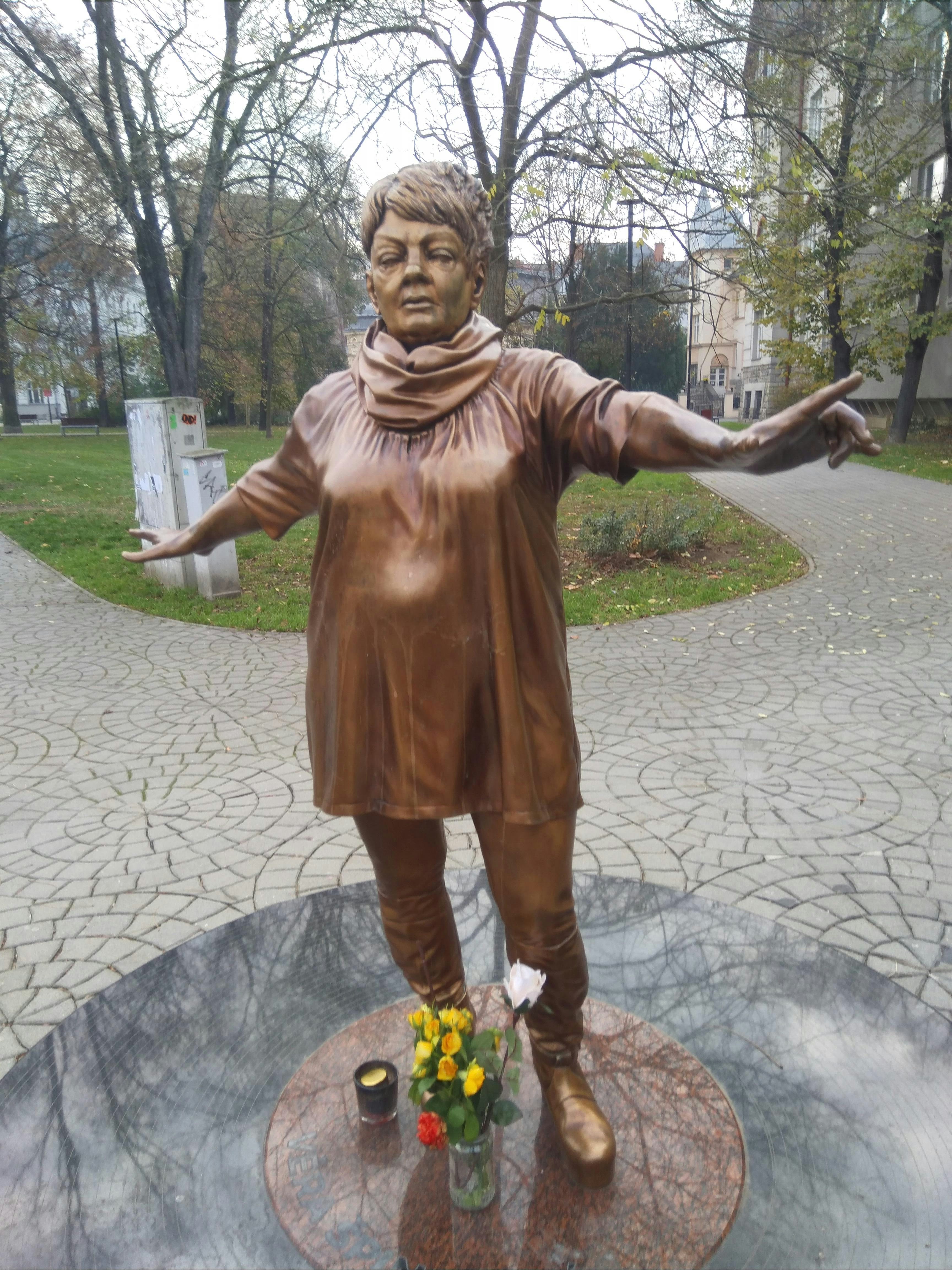 Outstretched Bronze: Park Statue Reaching Across the Path