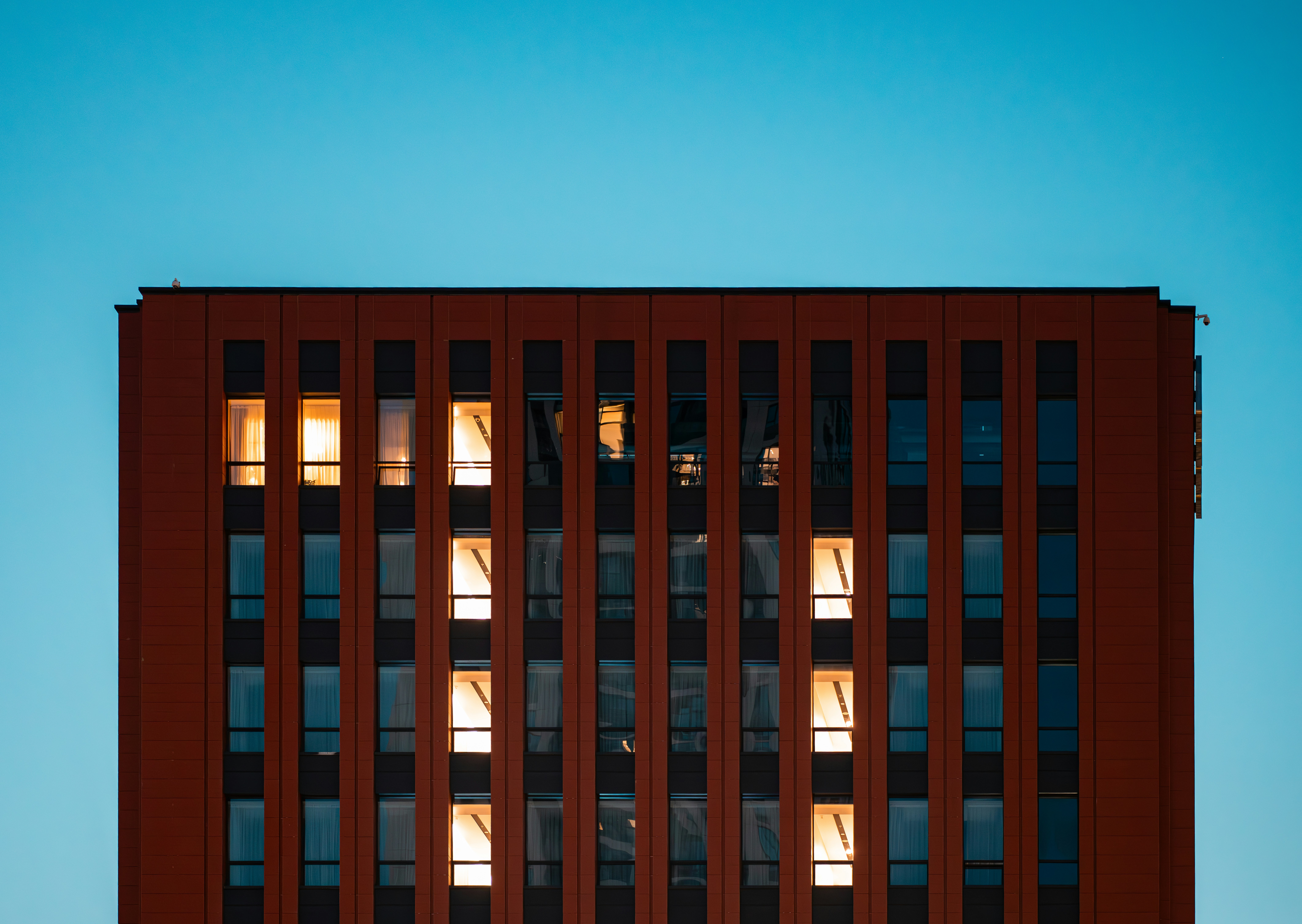 A tall building with lots of windows lit up at night photo – Free ...