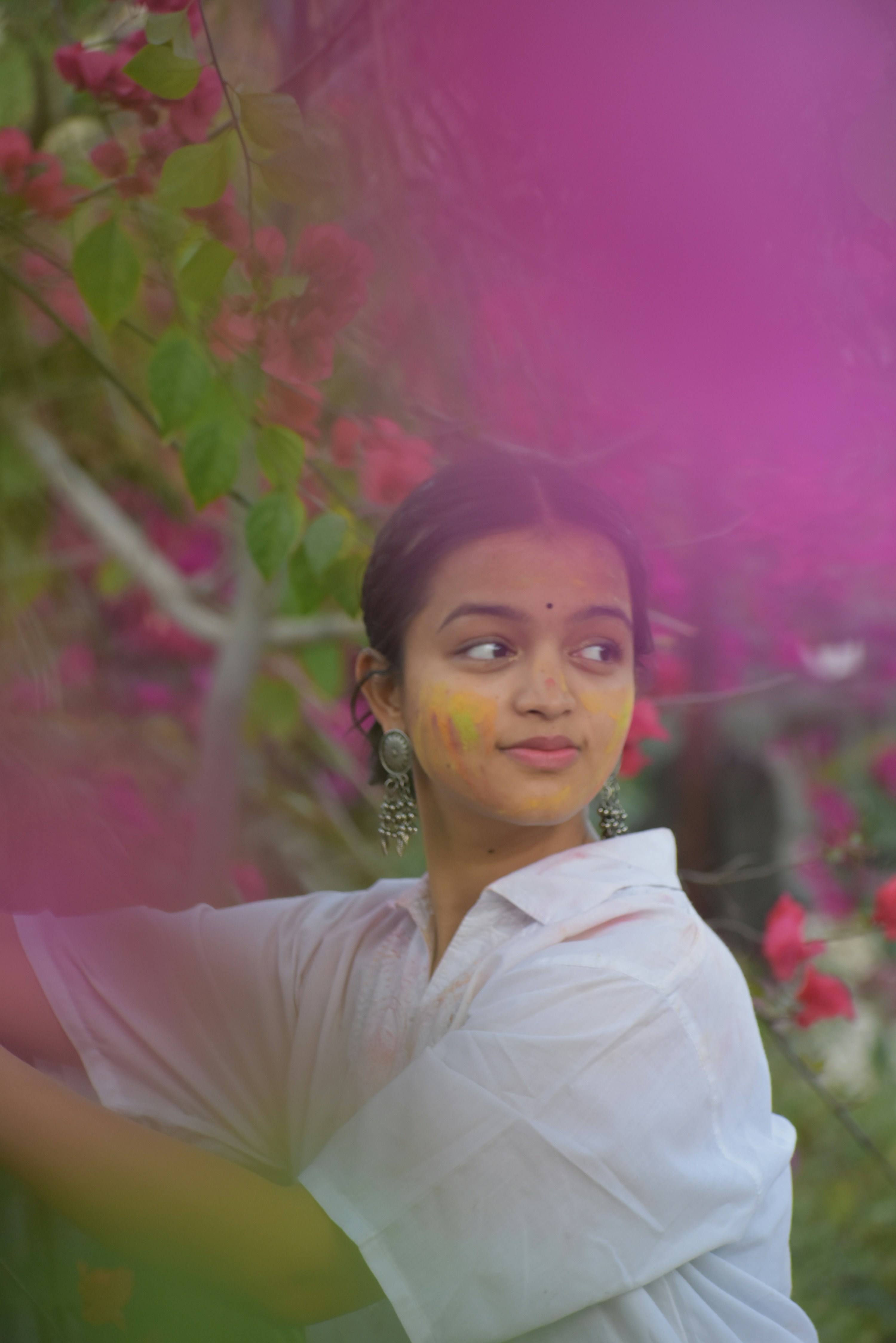 A woman standing in front of a bush with pink flowers photo – Free ...